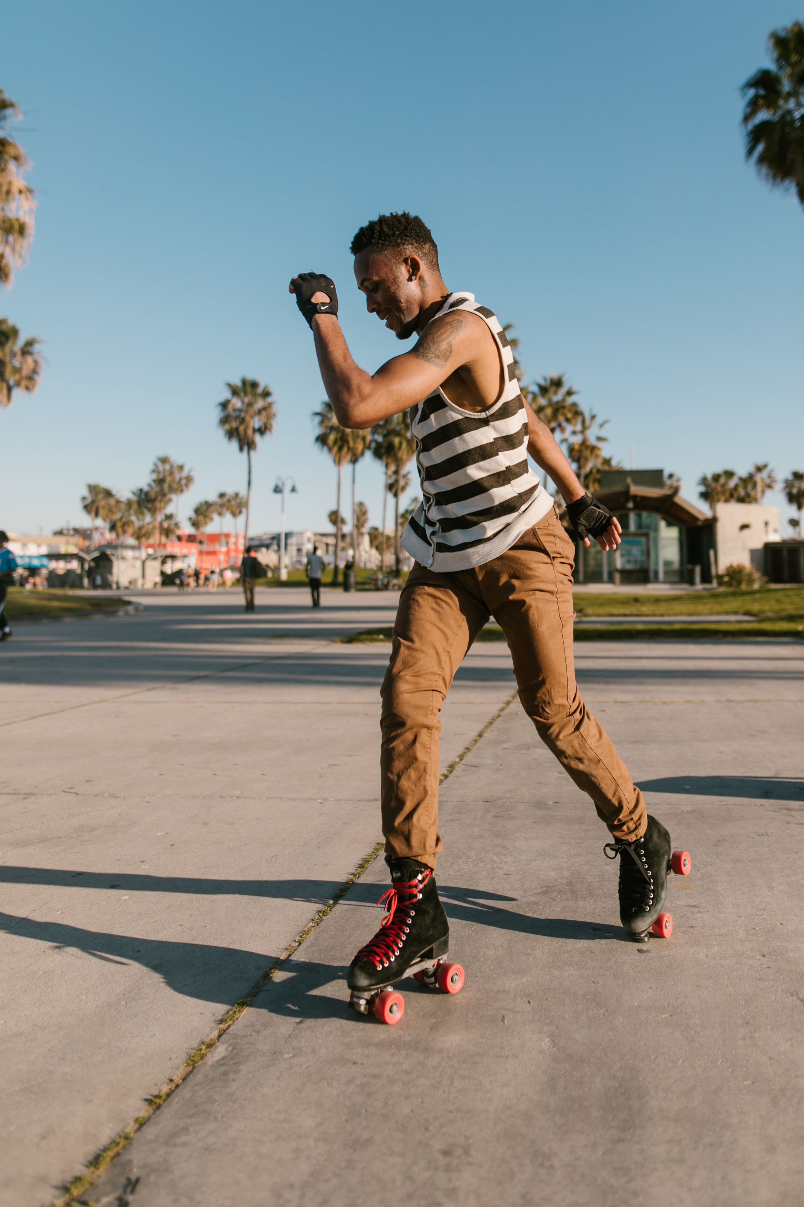 A Man in a Striped Tank Top Roller Skating · Free Stock Photo