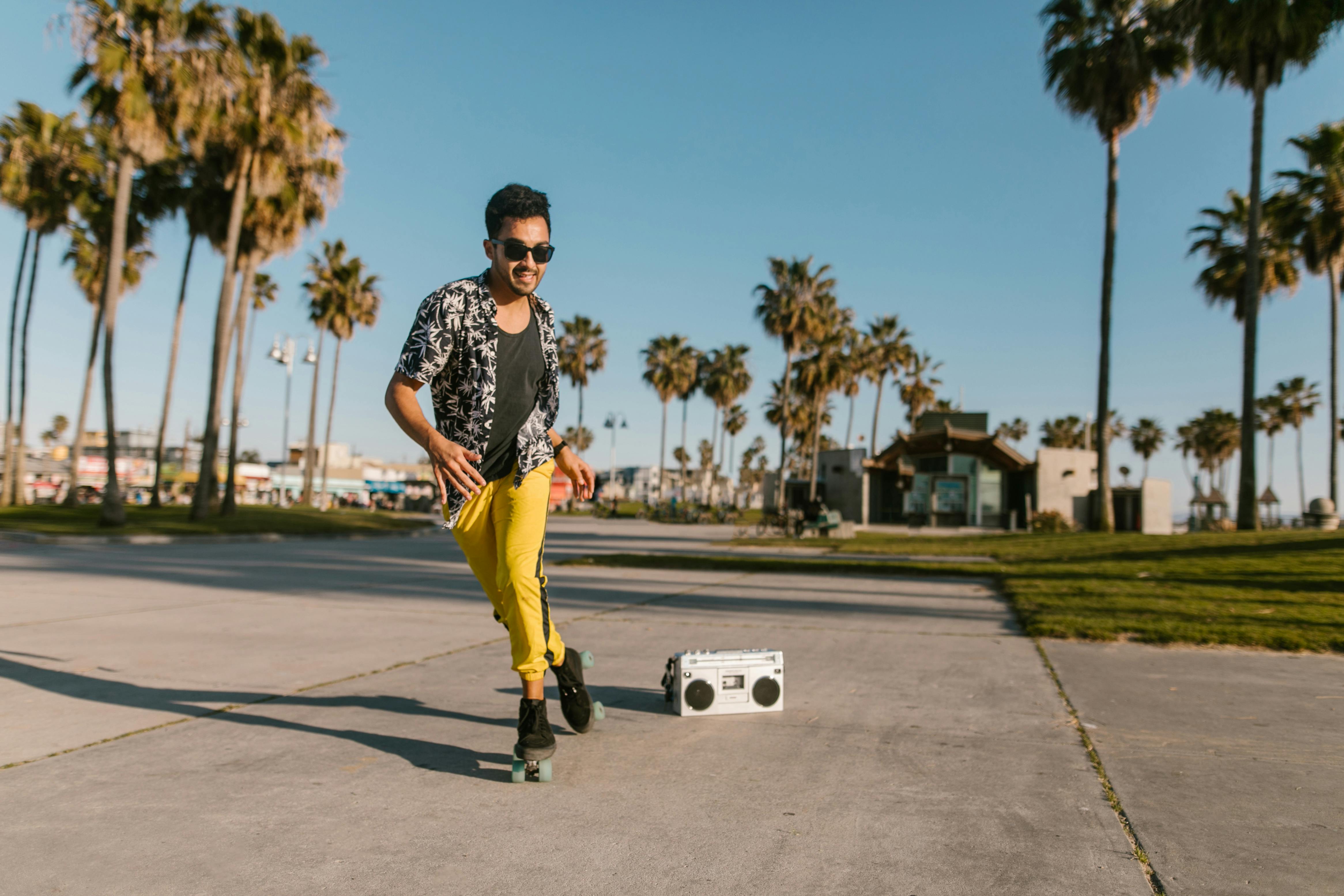 A Man with Sunglasses Roller Skating Near a Boombox · Free Stock Photo