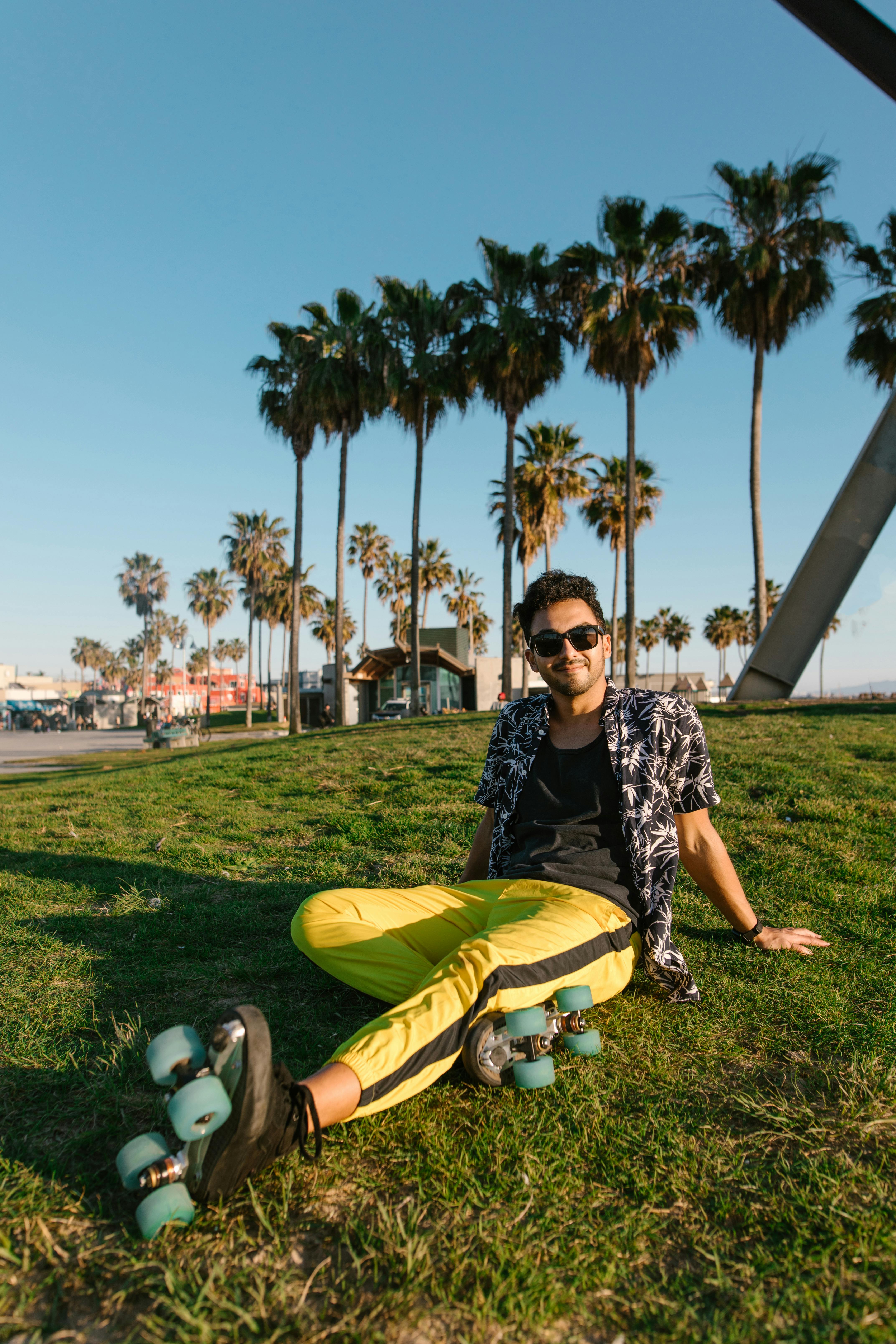 Man with Roller Skates Sitting on Grass · Free Stock Photo