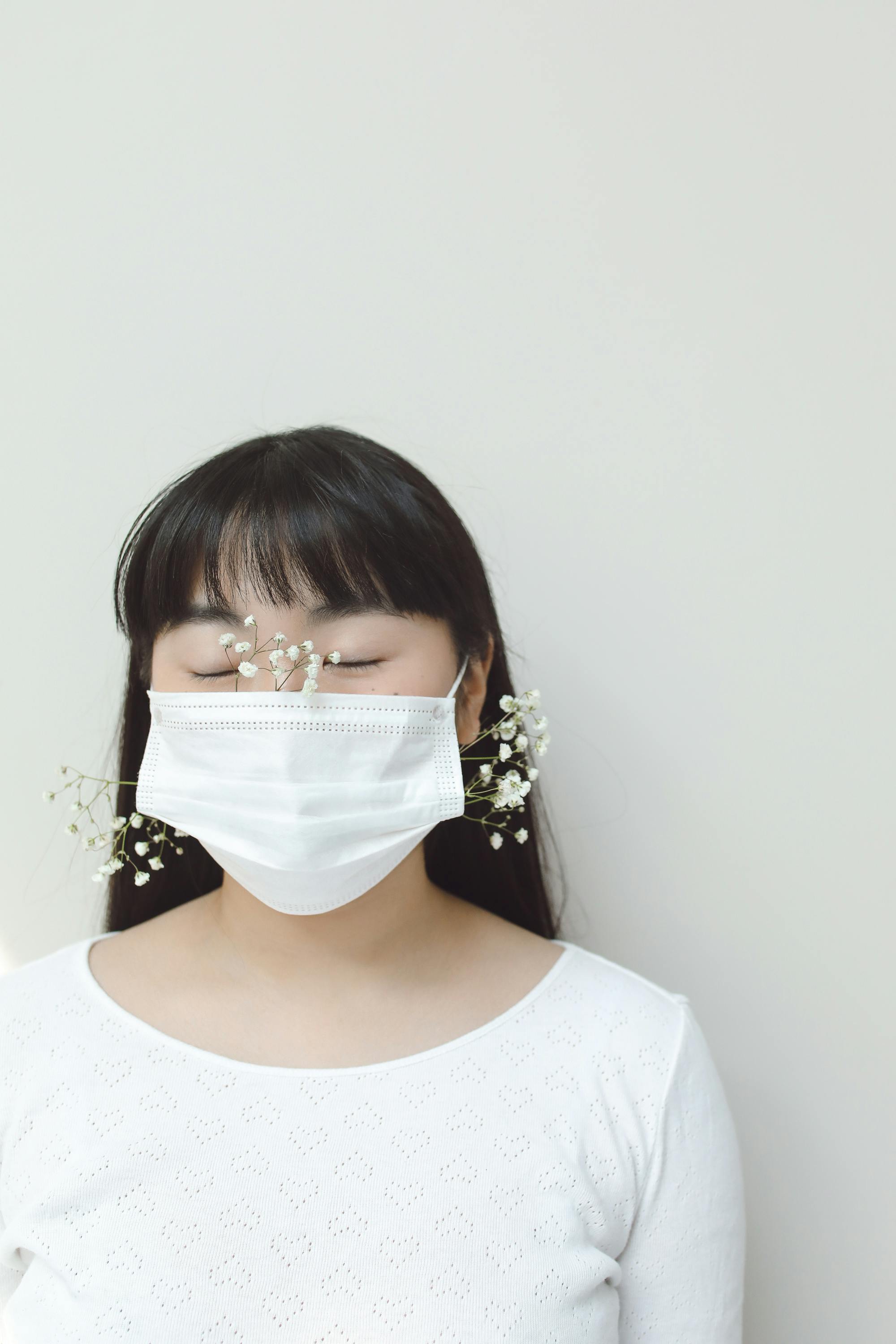 Portrait of a Woman in a Face Mask with Flower Stuck Behind It · Free ...