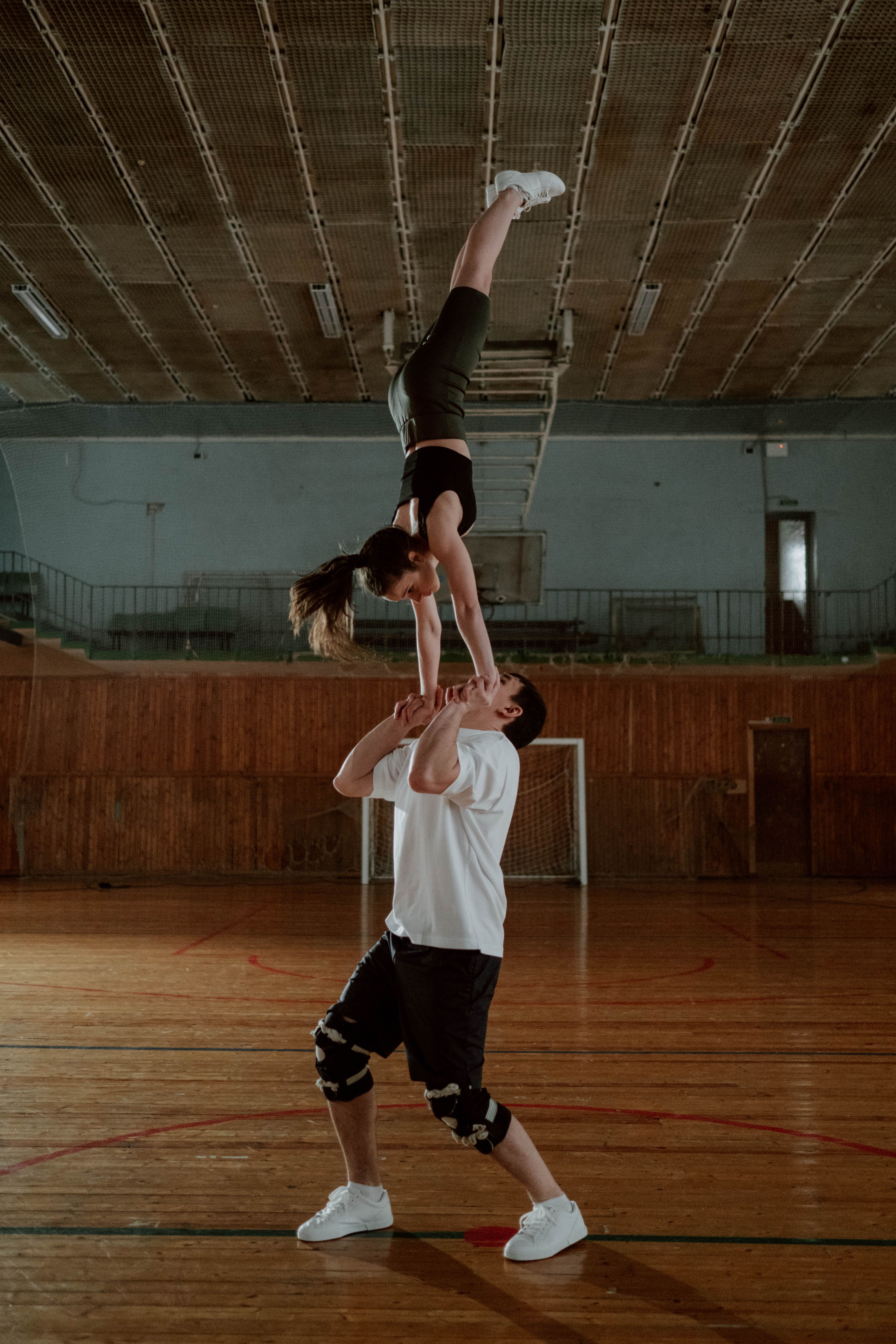 A Man in White Shirt Lifting a Woman Above His Head · Free Stock Photo