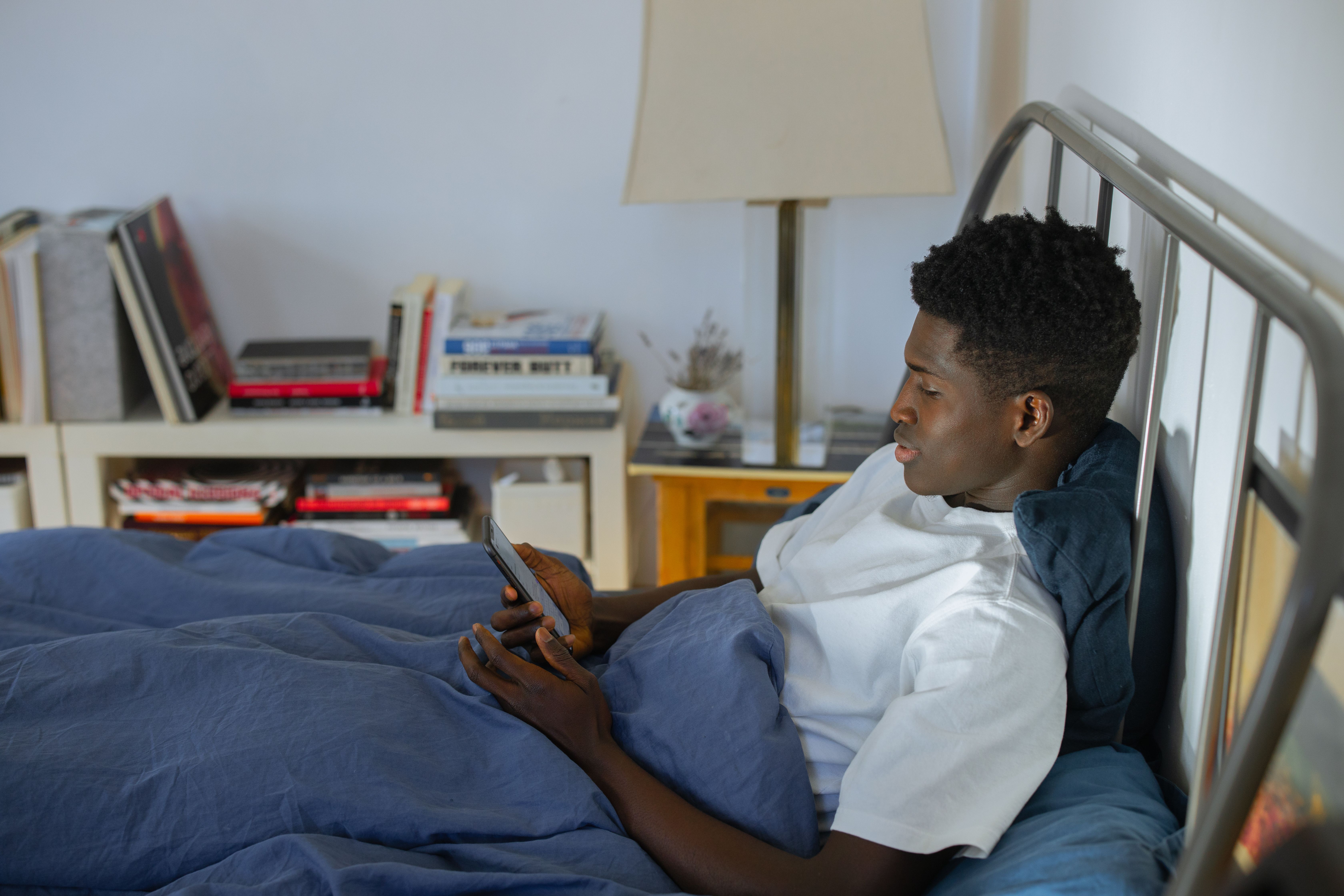 Man Using Phone while on Bed · Free Stock Photo