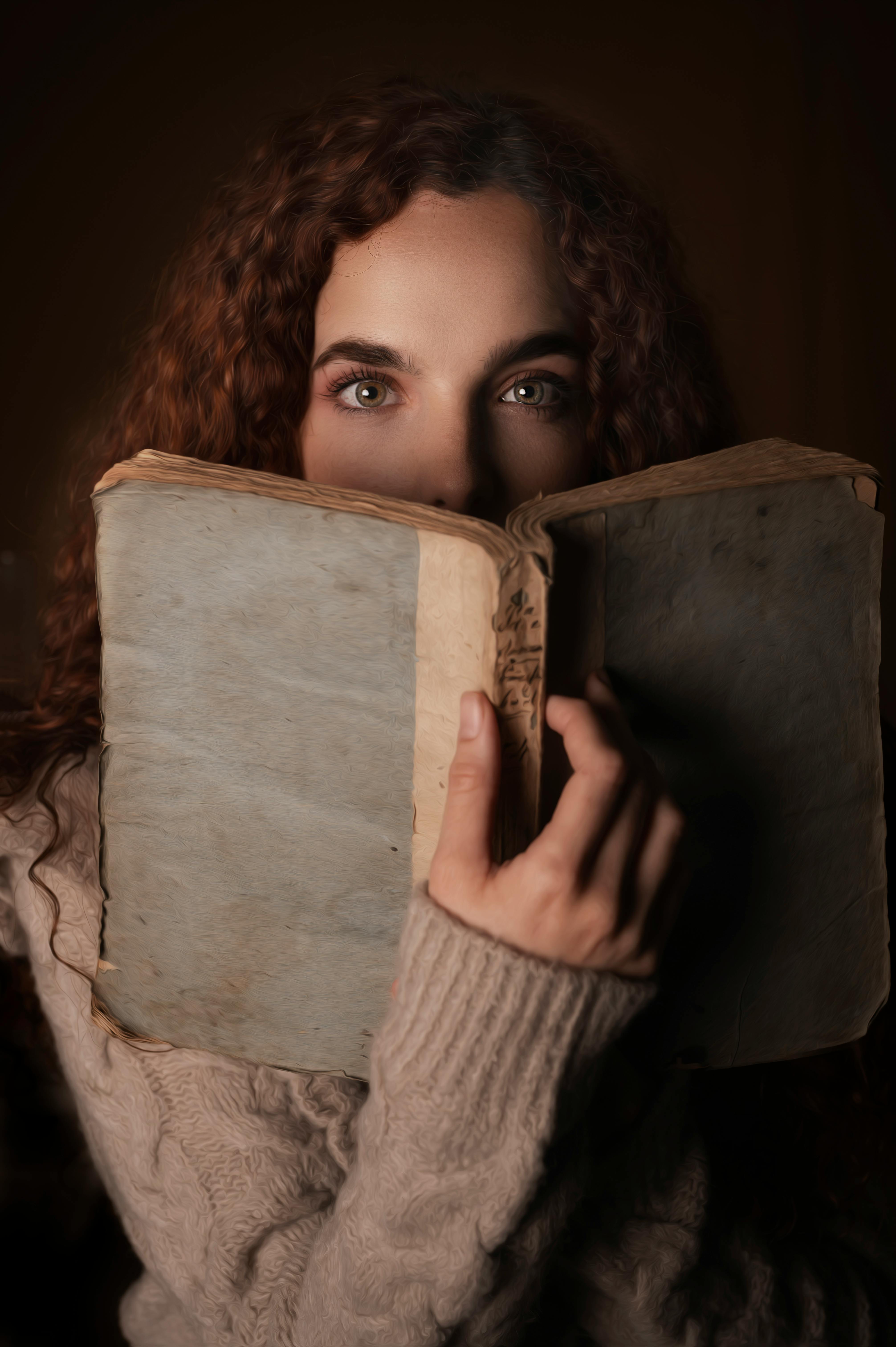 A Woman in White Knit Sweater Holding a Book · Free Stock Photo