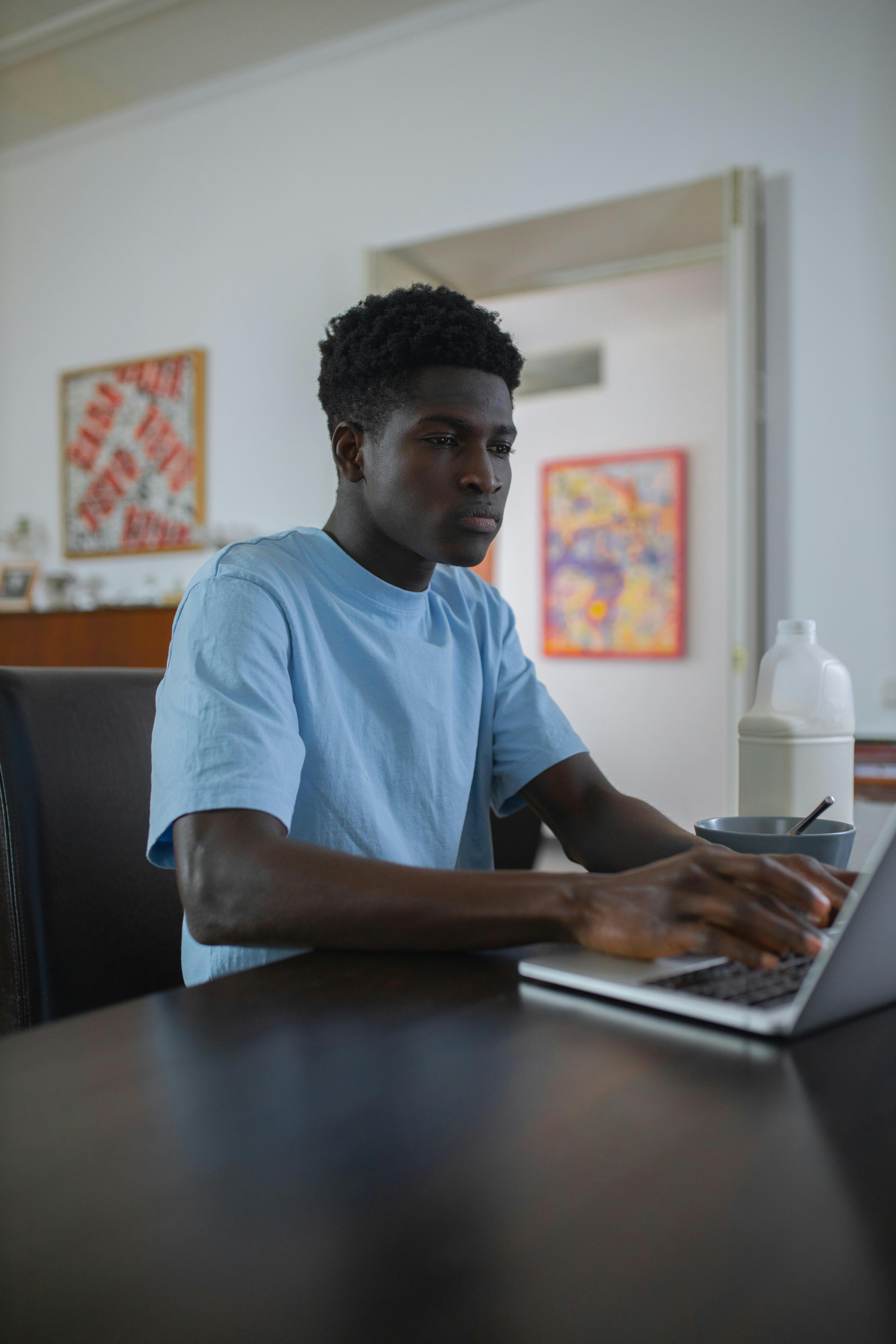 A Man in Blue Plaid Long Sleeves Using a Laptop · Free Stock Photo