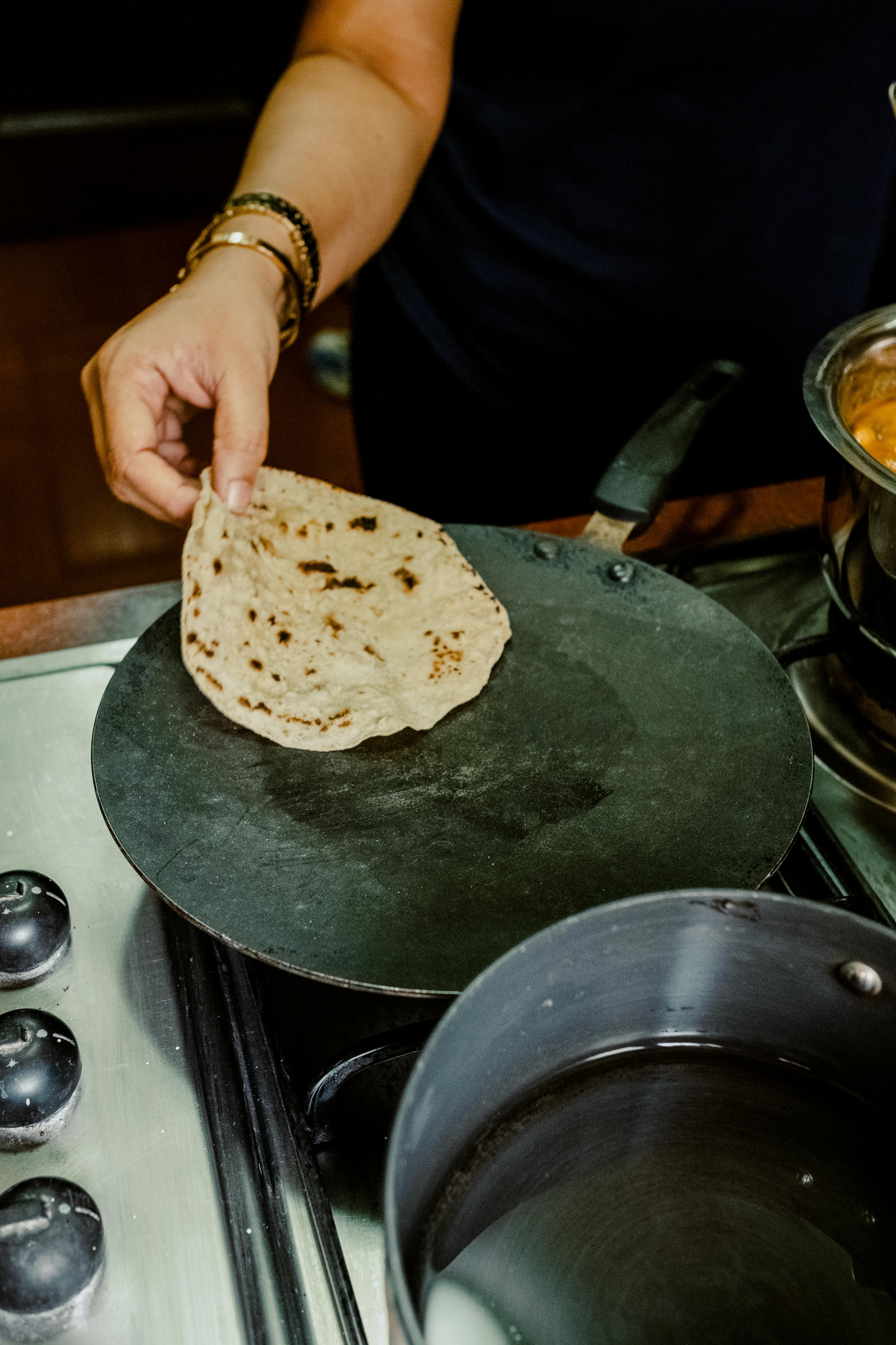 A Person Cooking Chapati on Tava · Free Stock Photo