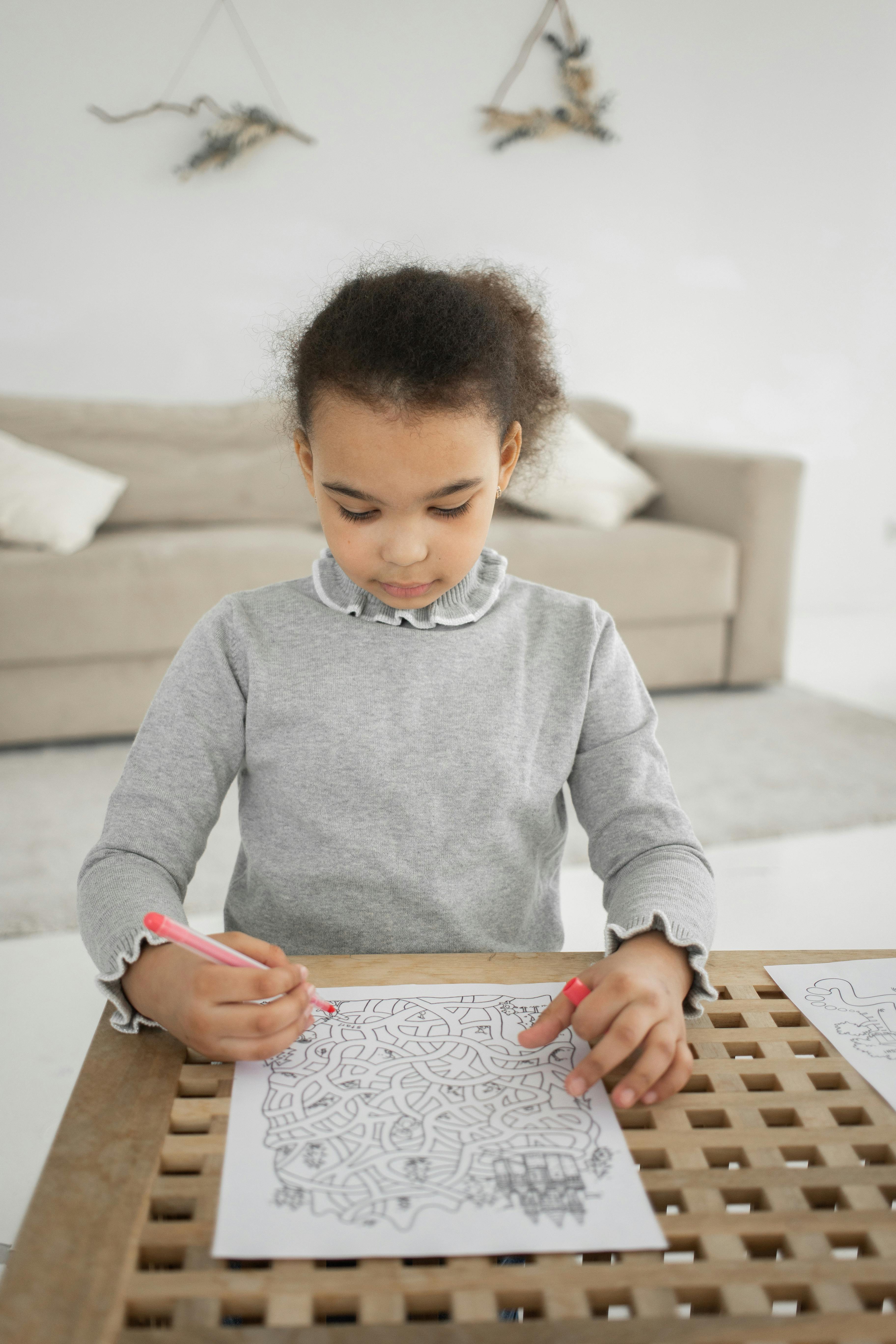 Girl looking at paper with labyrinth · Free Stock Photo