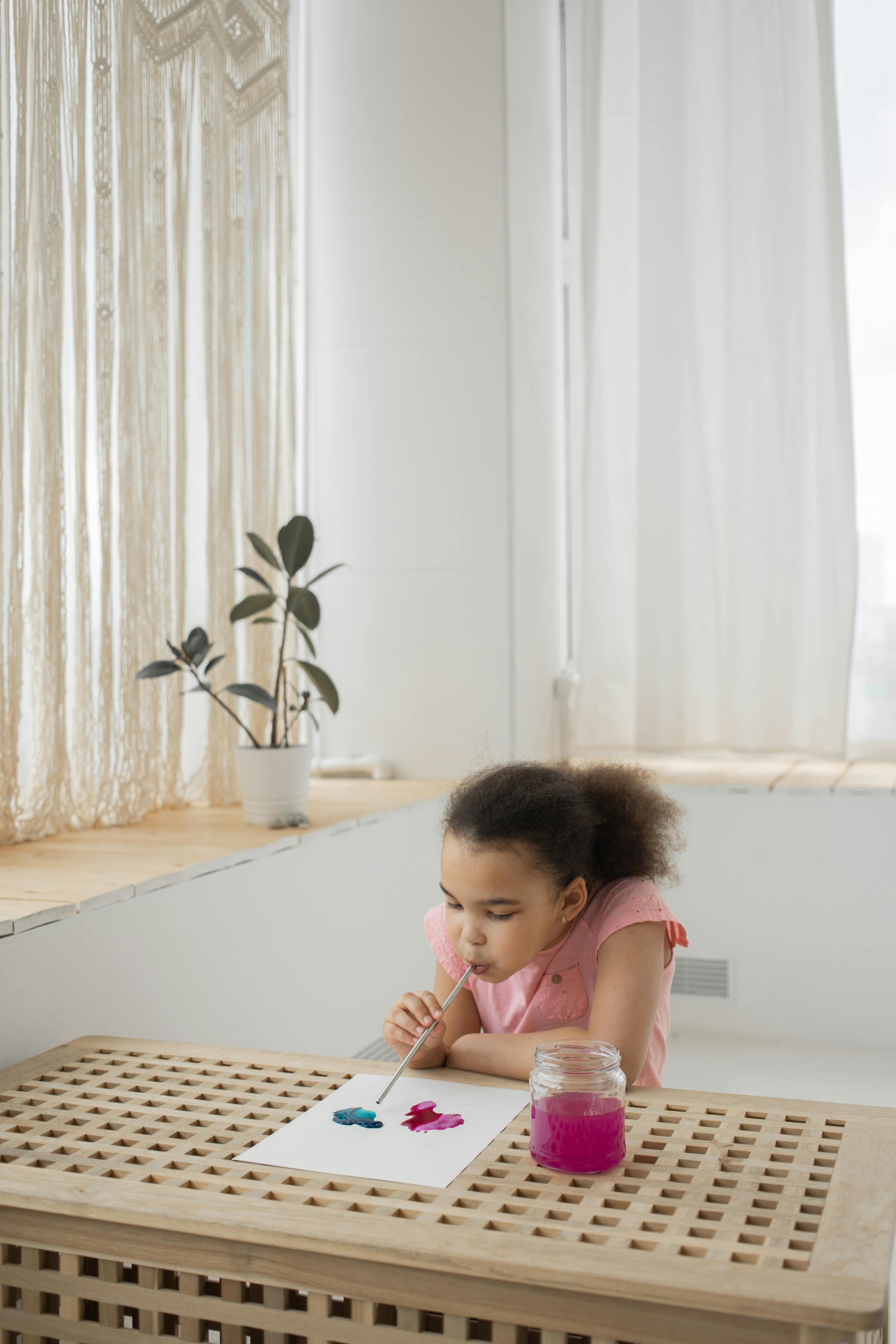 Attentive black child drawing on paper at home · Free Stock Photo