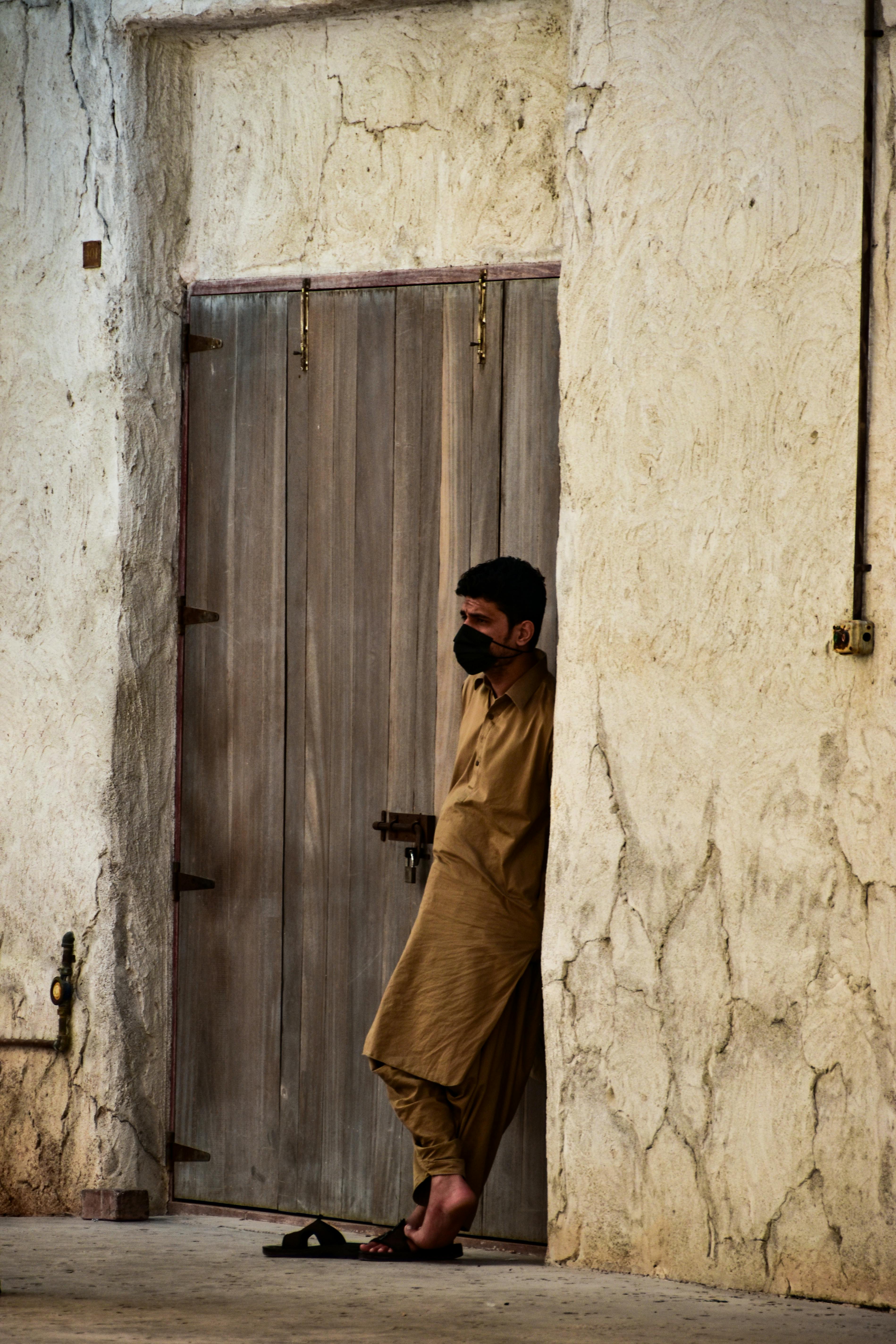 A Man Leaning on a Wooden Door · Free Stock Photo