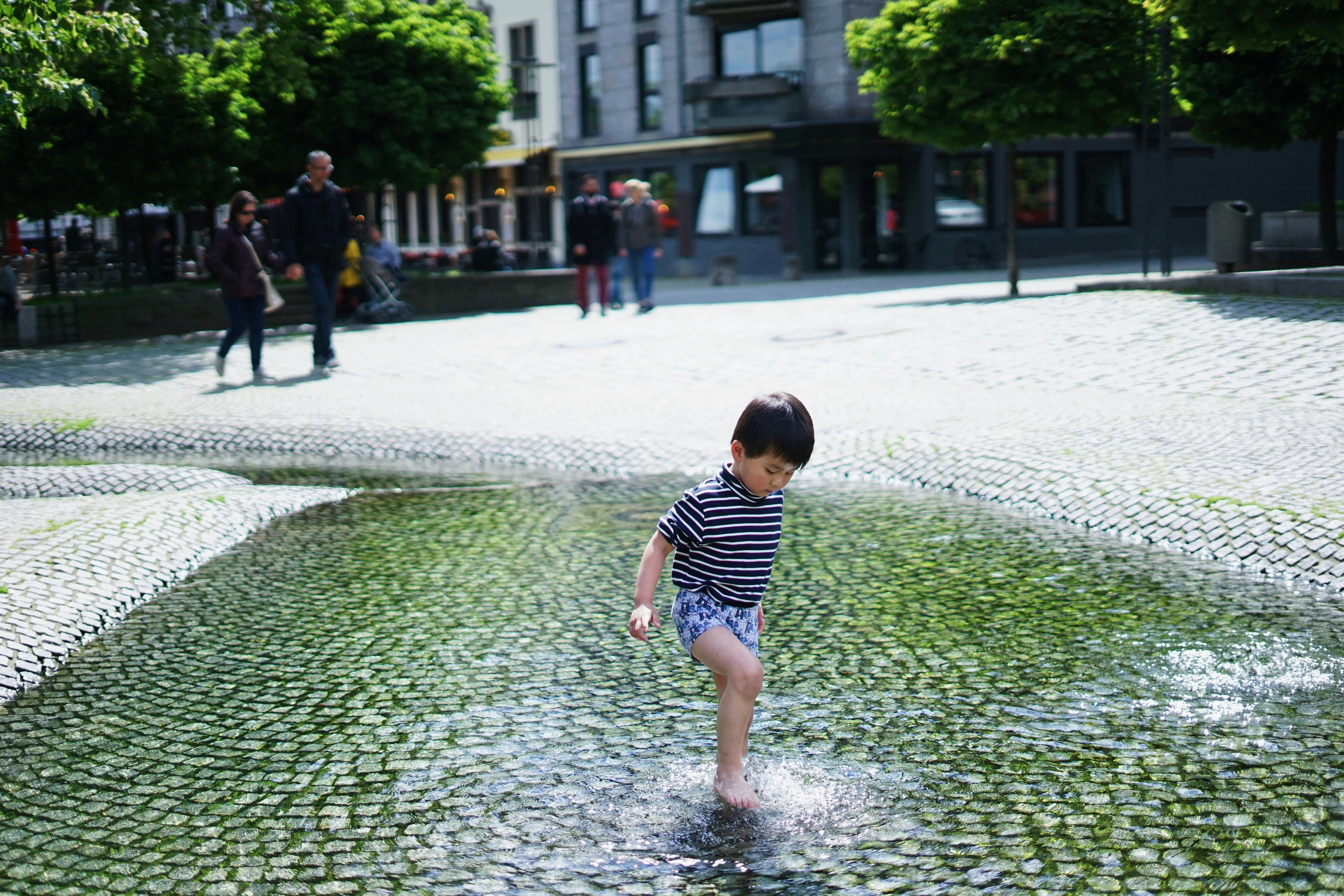 Little Asian boy in puddle · Free Stock Photo