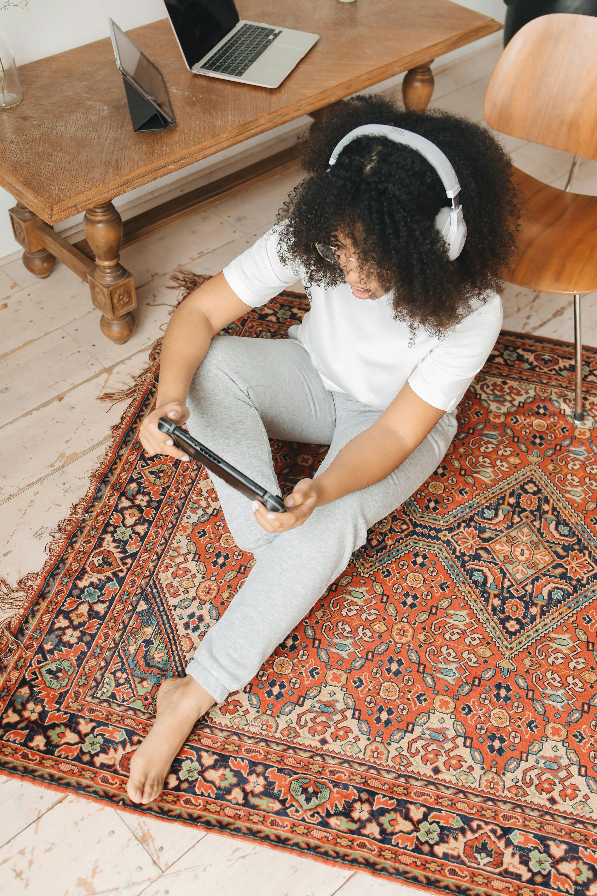 A Person Sitting on Rug with Headphones · Free Stock Photo