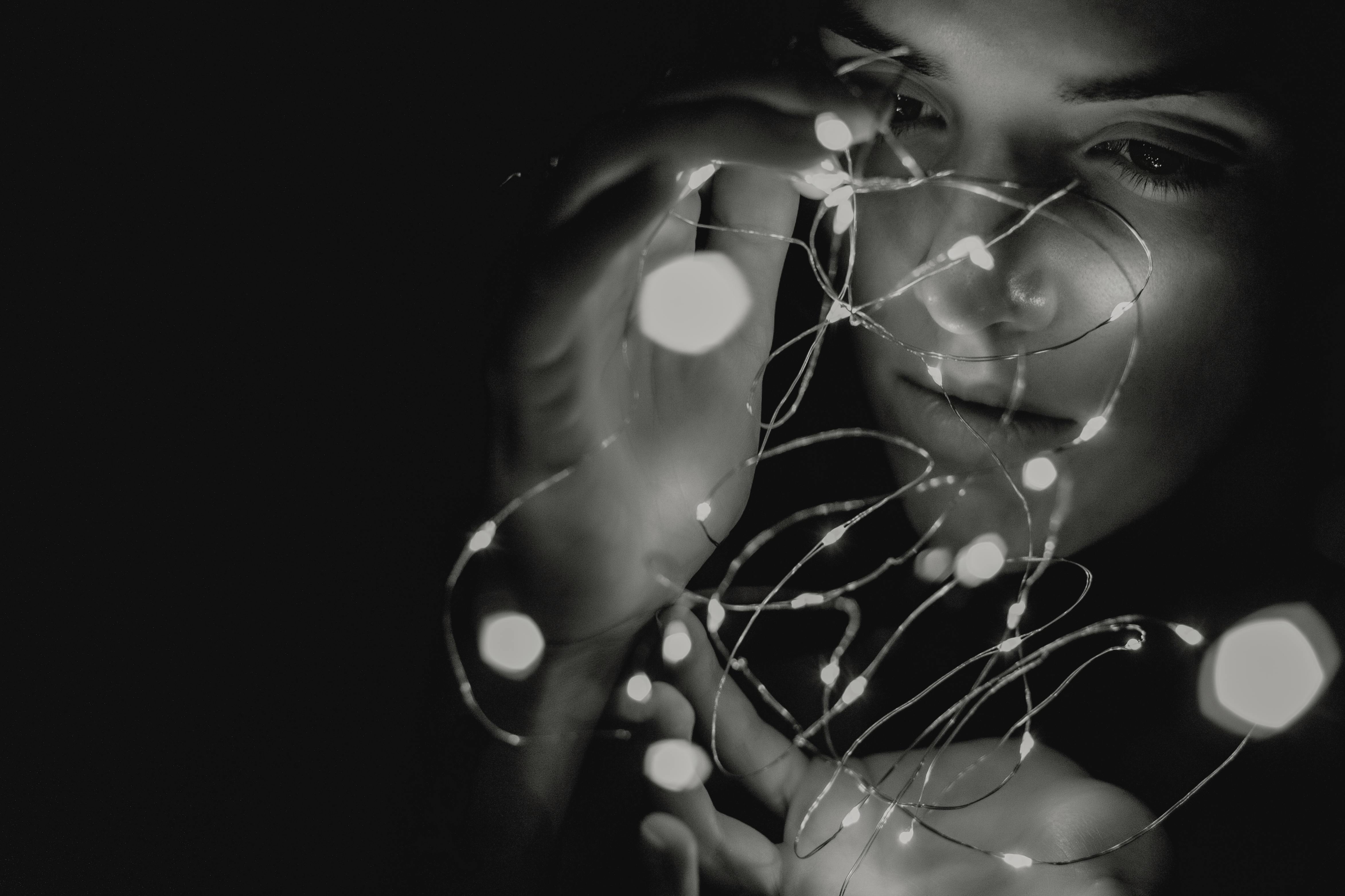 A Woman's Face Illuminated by String Lights · Free Stock Photo