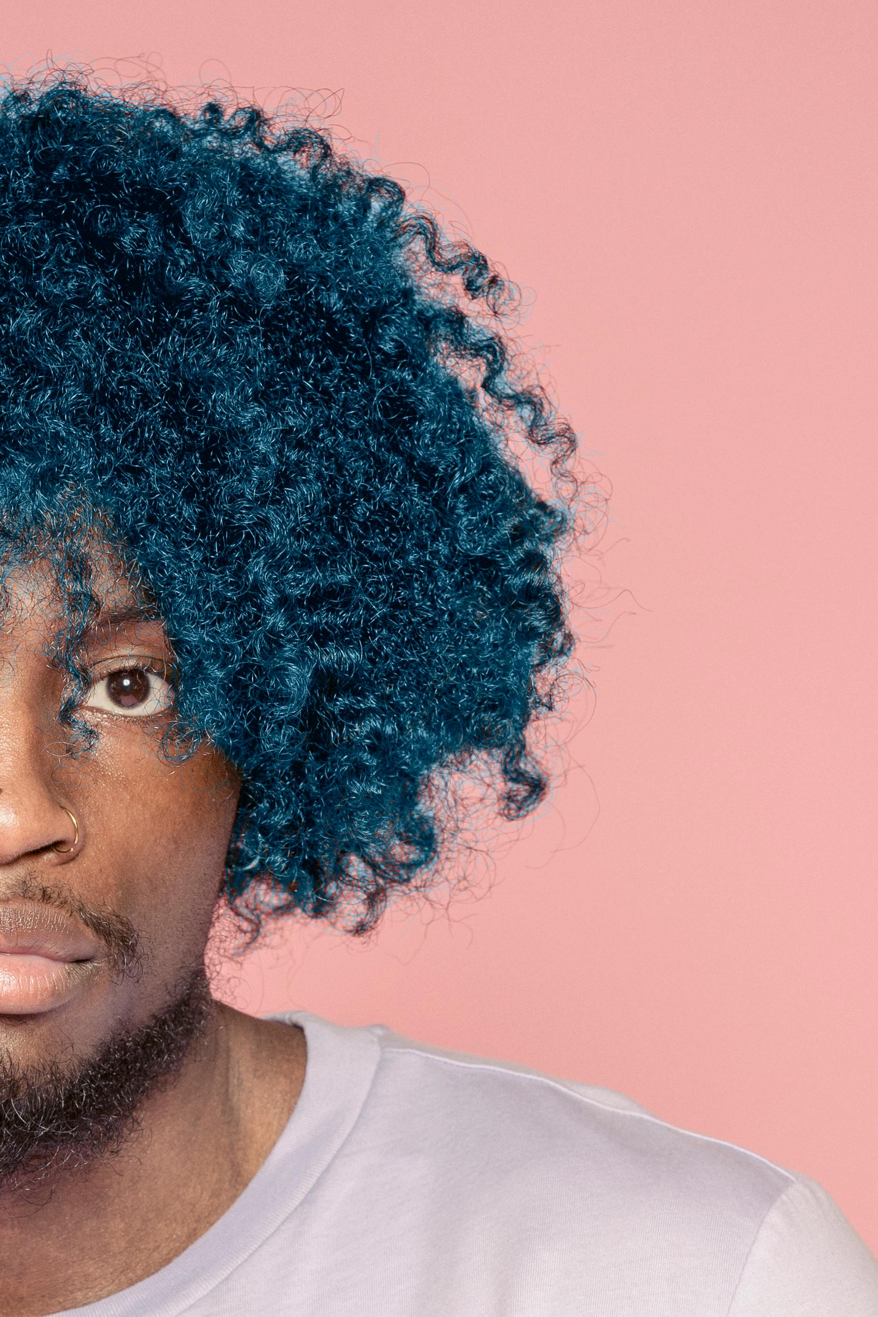 Black curly haired man with unemotional face · Free Stock Photo