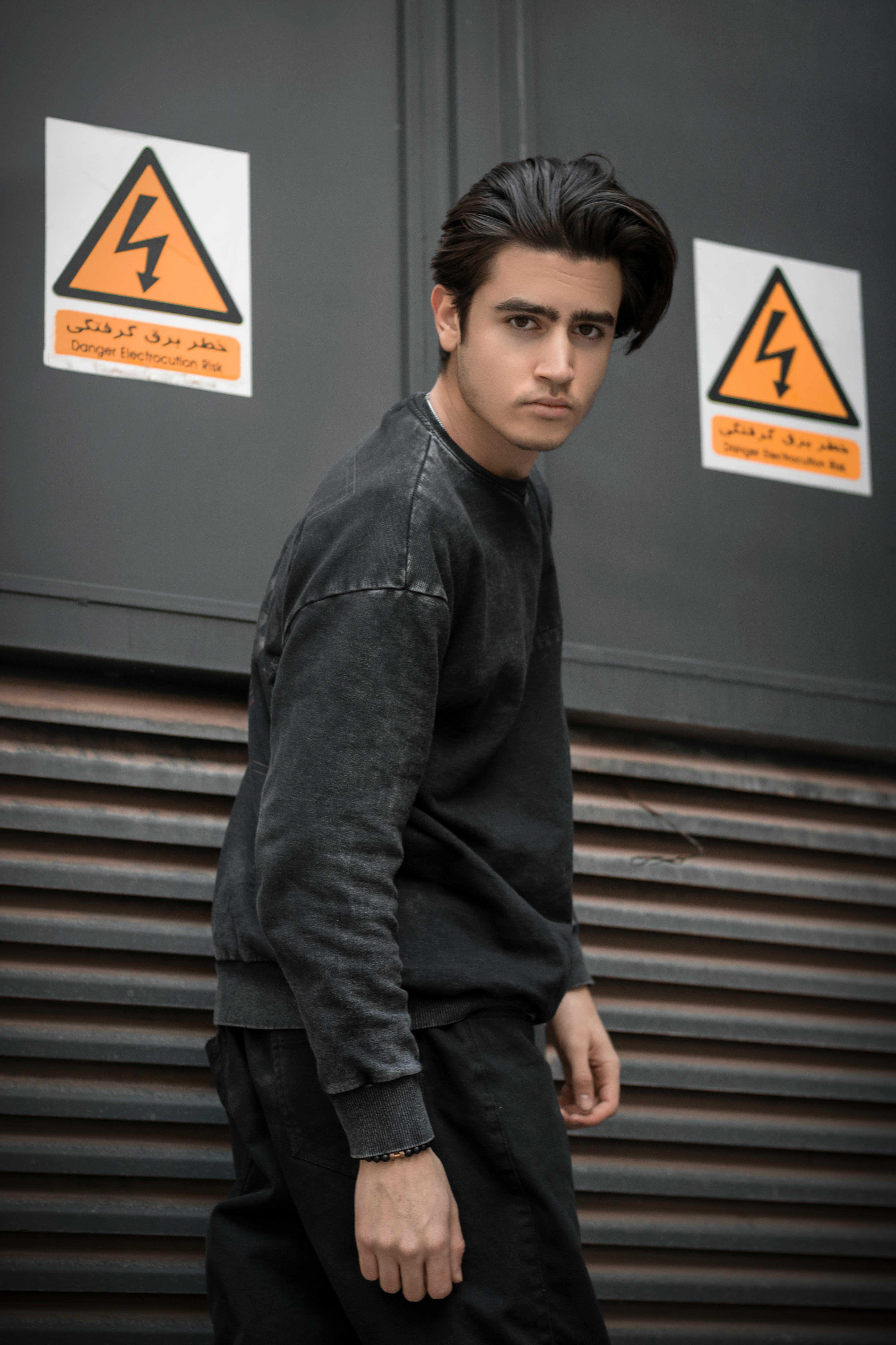 Good Looking Man Standing Beside a Warning Signs · Free Stock Photo