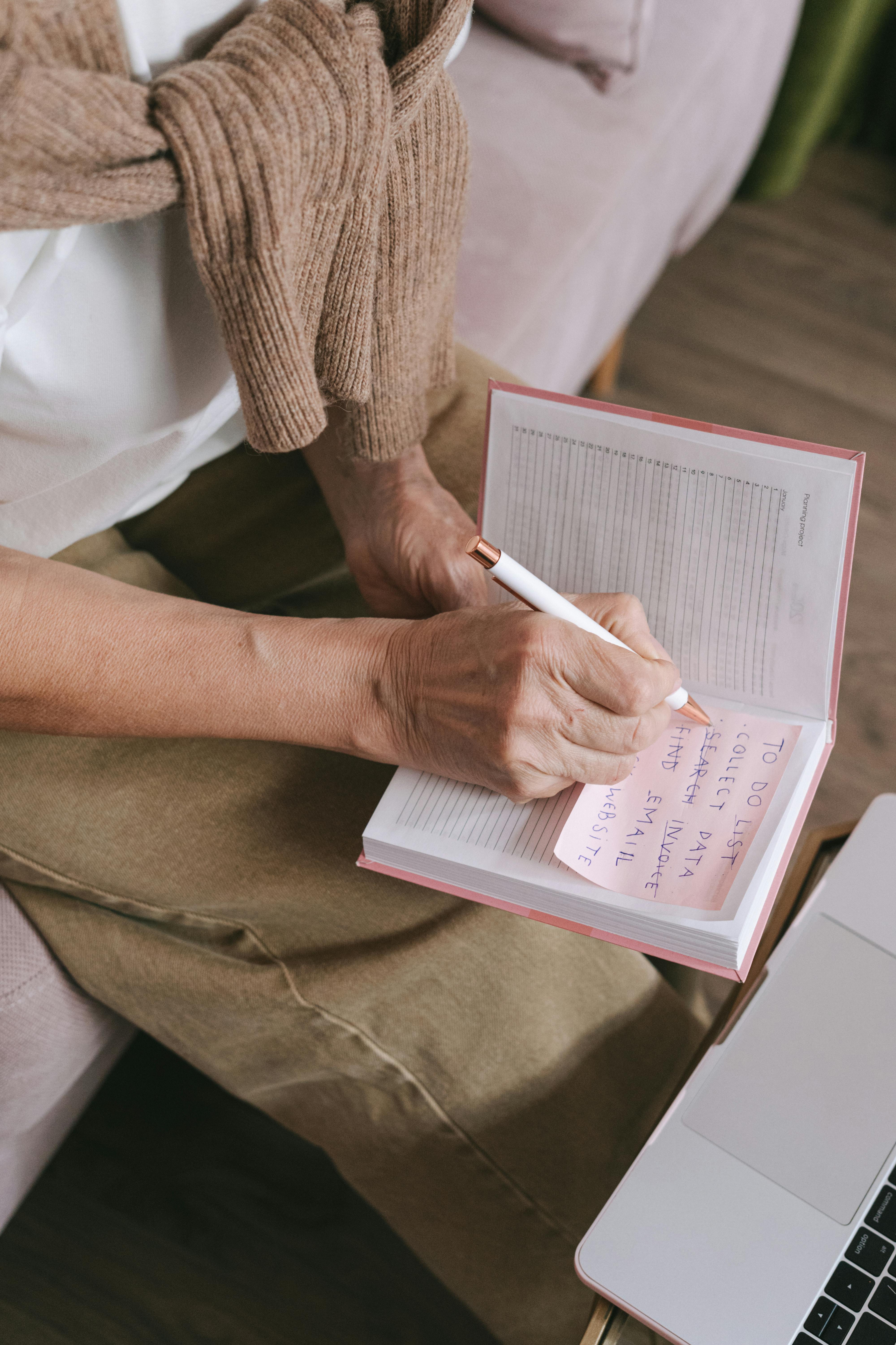 Person Writing on Notebook · Free Stock Photo
