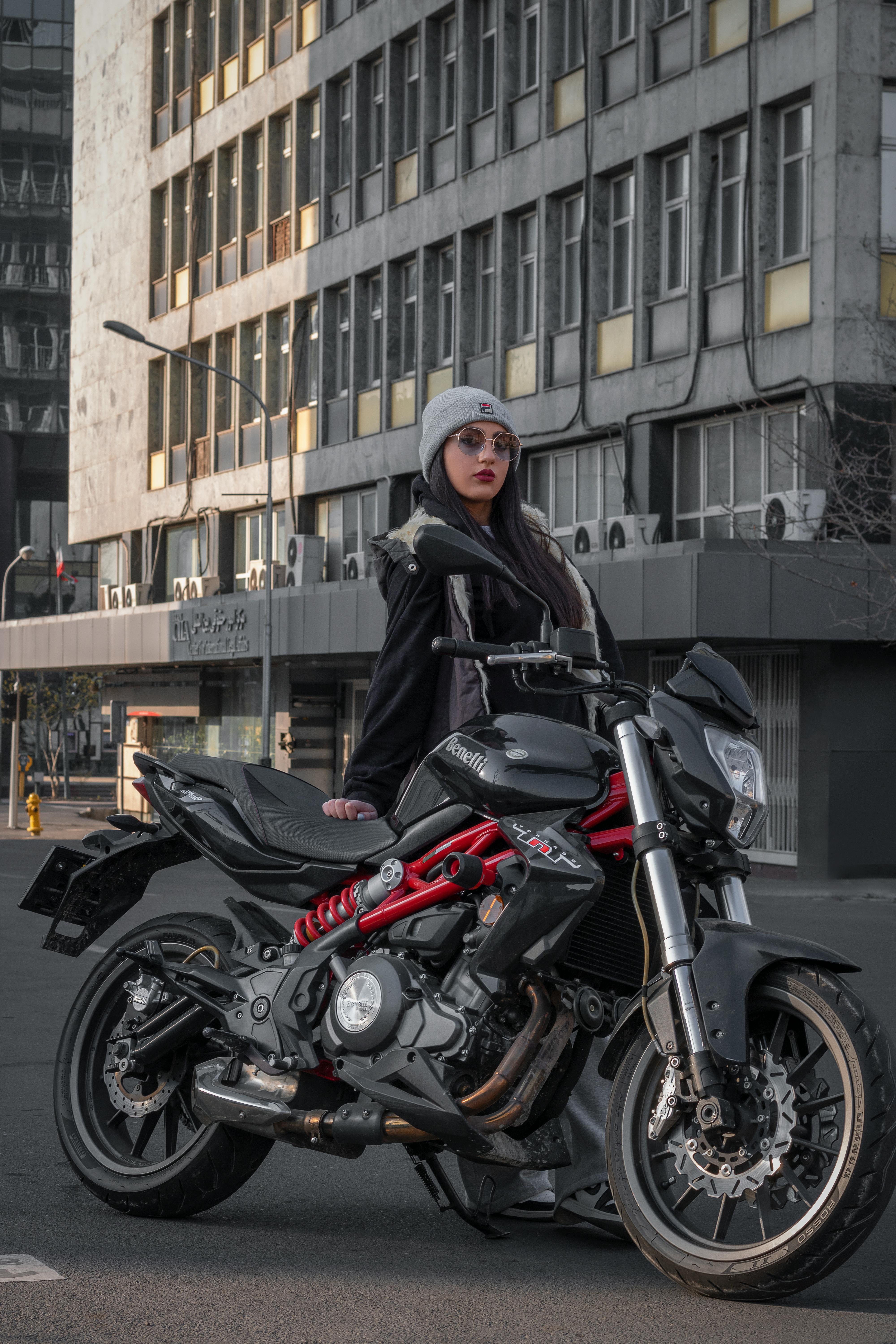 Pretty Girl Standing Beside a Black Motorcycle · Free Stock Photo