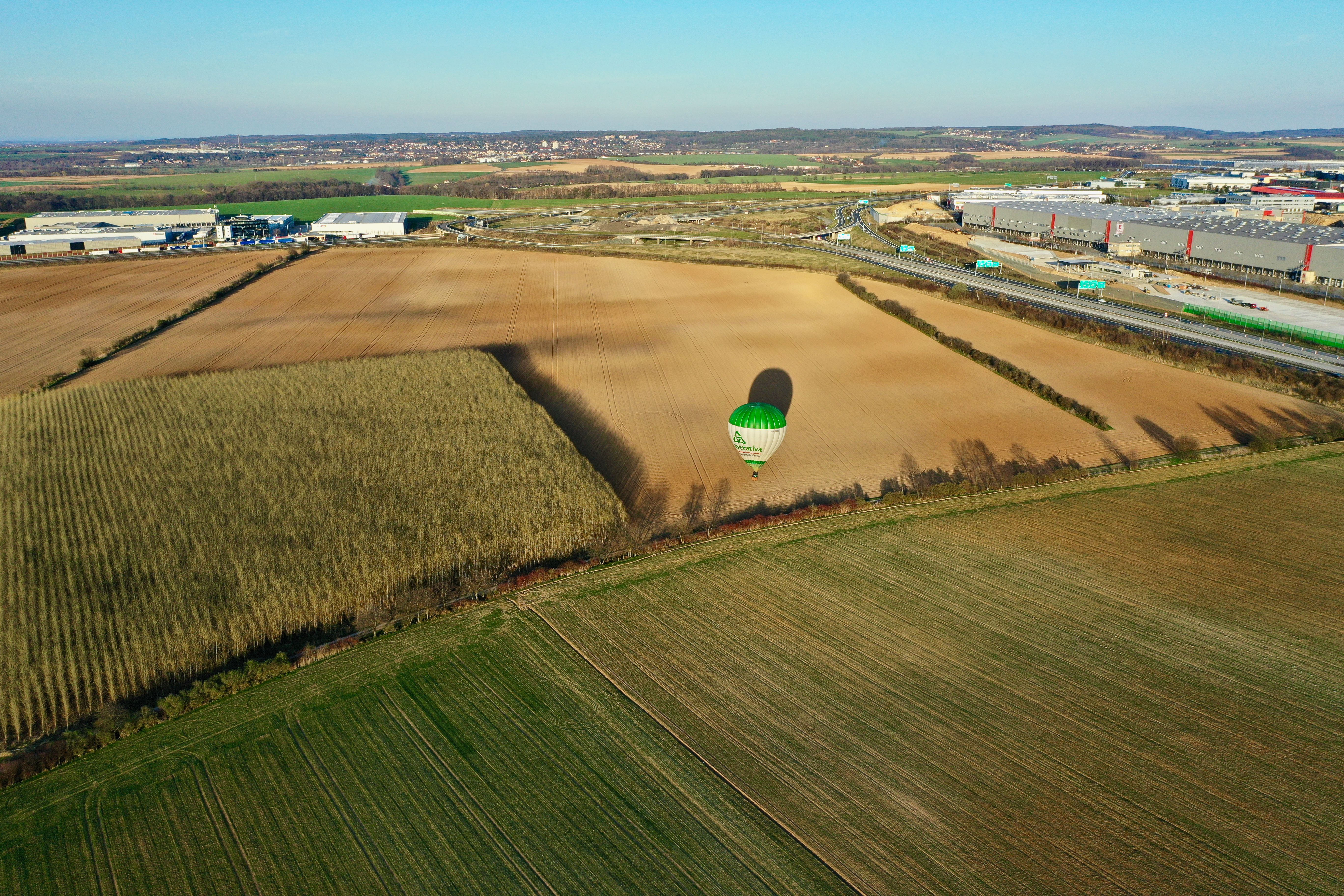 a Hot Air Balloon Flying over a Farm Field · Free Stock Photo