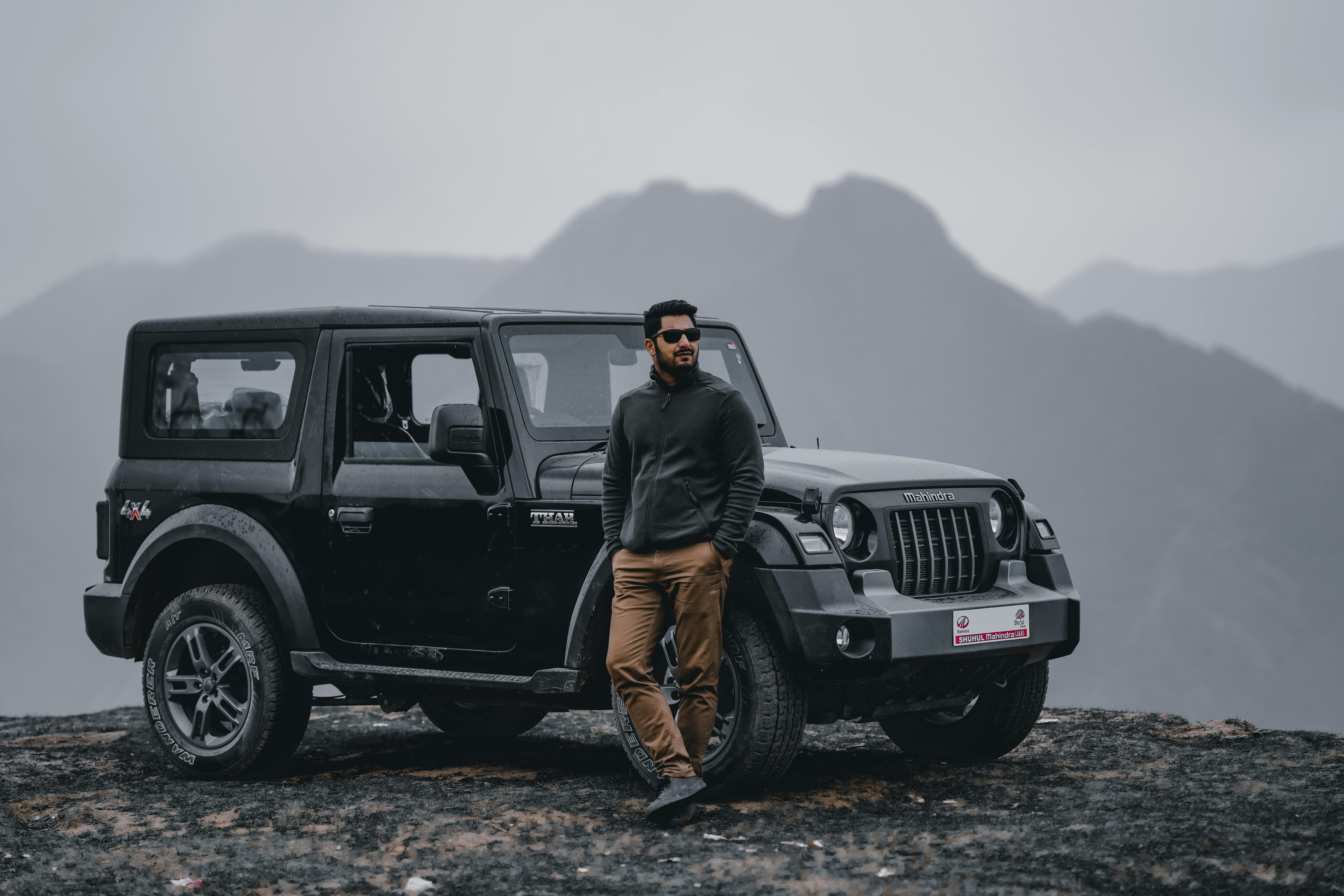 A Man Posing with A Black Jeep · Free Stock Photo
