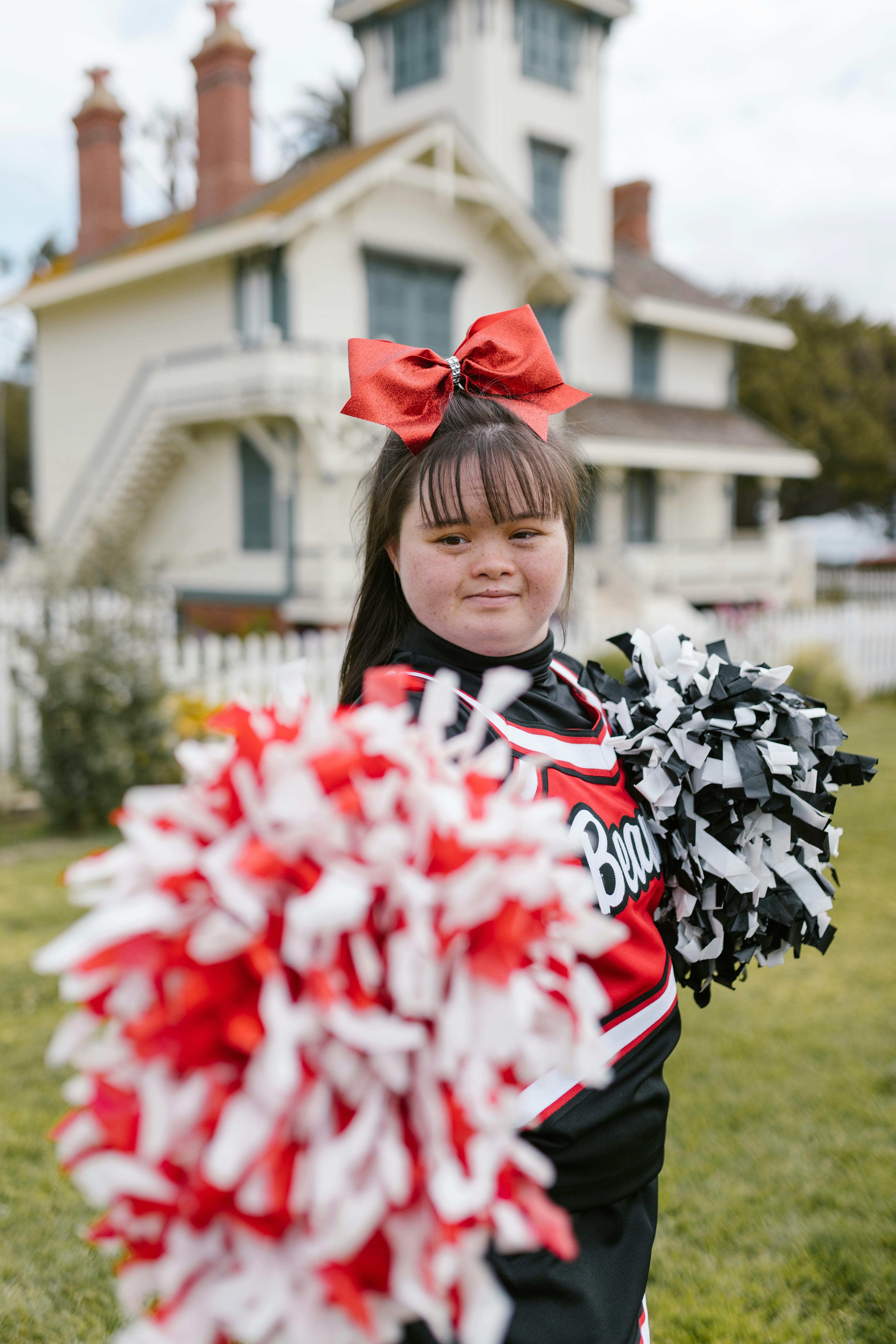 A Woman in Cheerleader Outfit Standing beside Pink Flowers · Free Stock ...