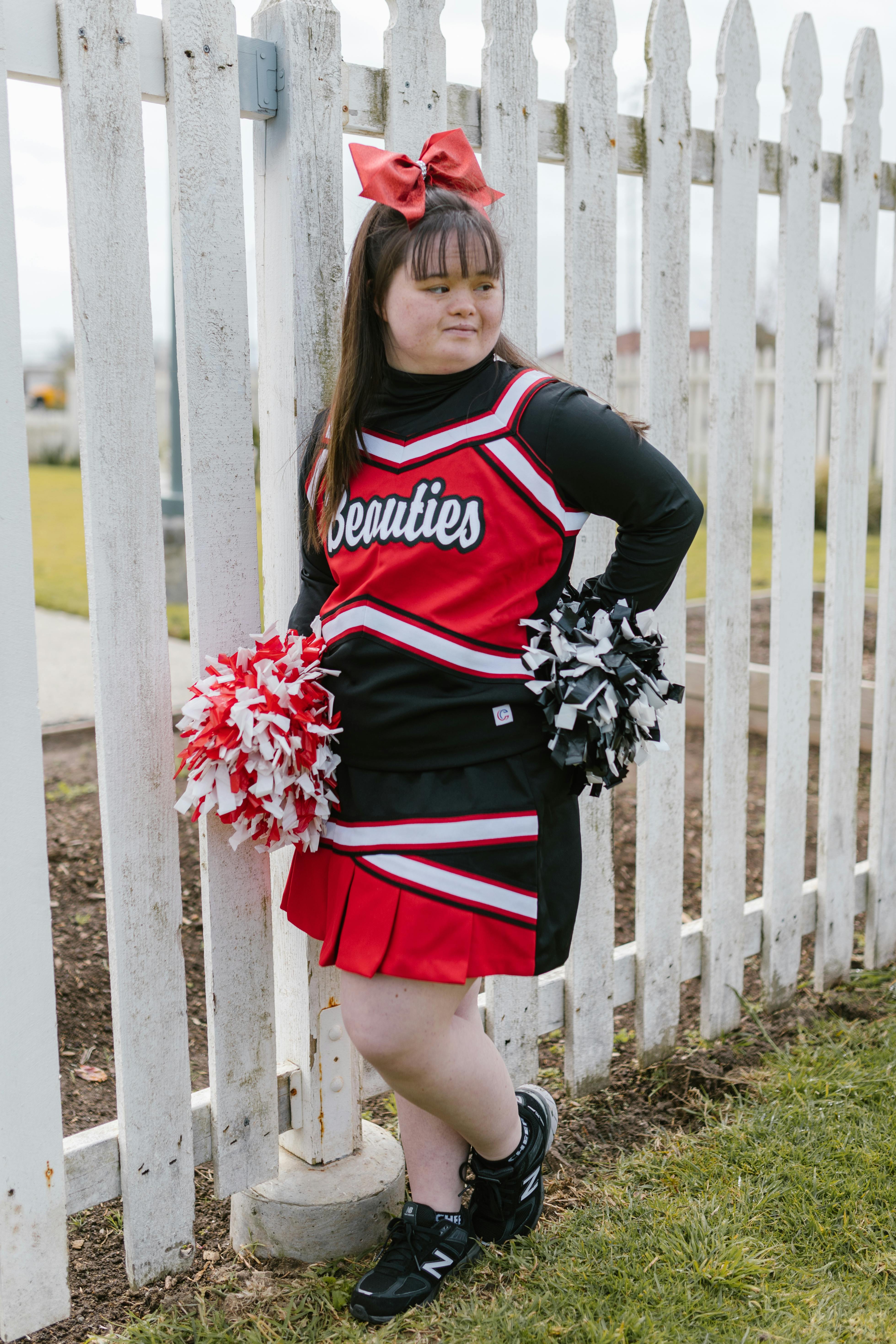 Woman in Cheerleader Outfit Standing beside Wooden Fence · Free Stock Photo