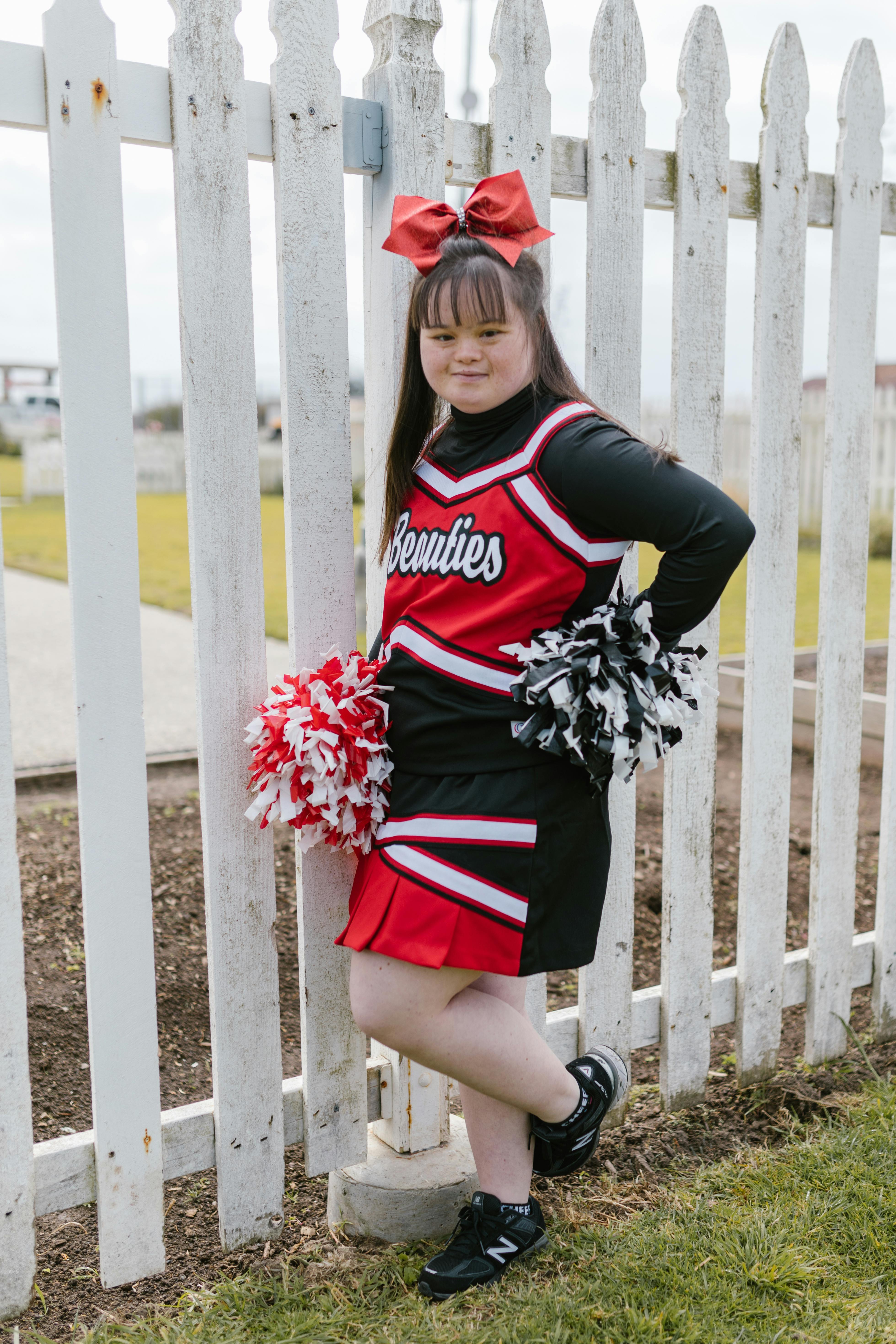 Woman in Cheerleader Outfit Standing beside Wooden Fence · Free Stock Photo