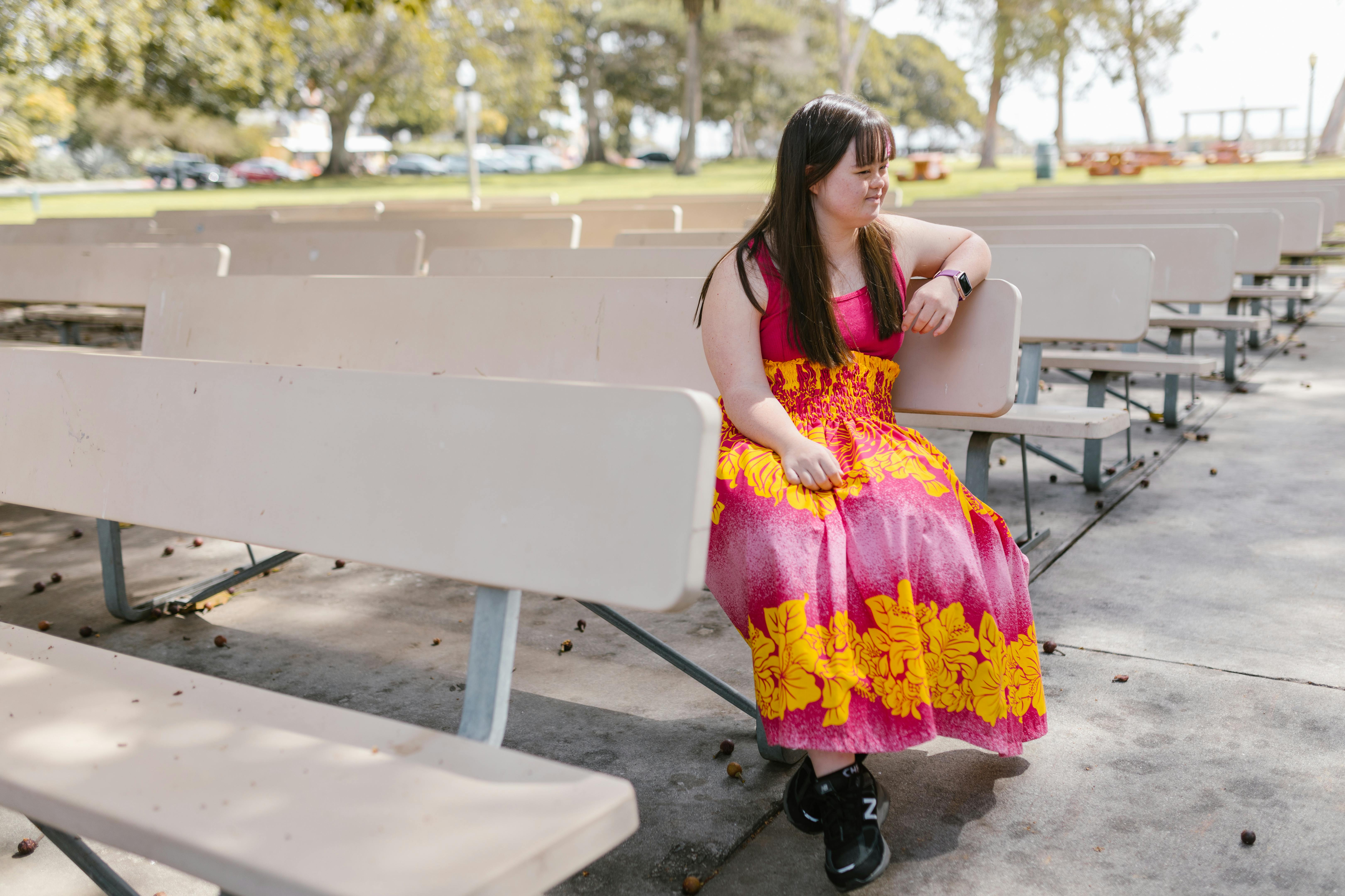 A Girl in Floral Dress Sitting on a Bench · Free Stock Photo