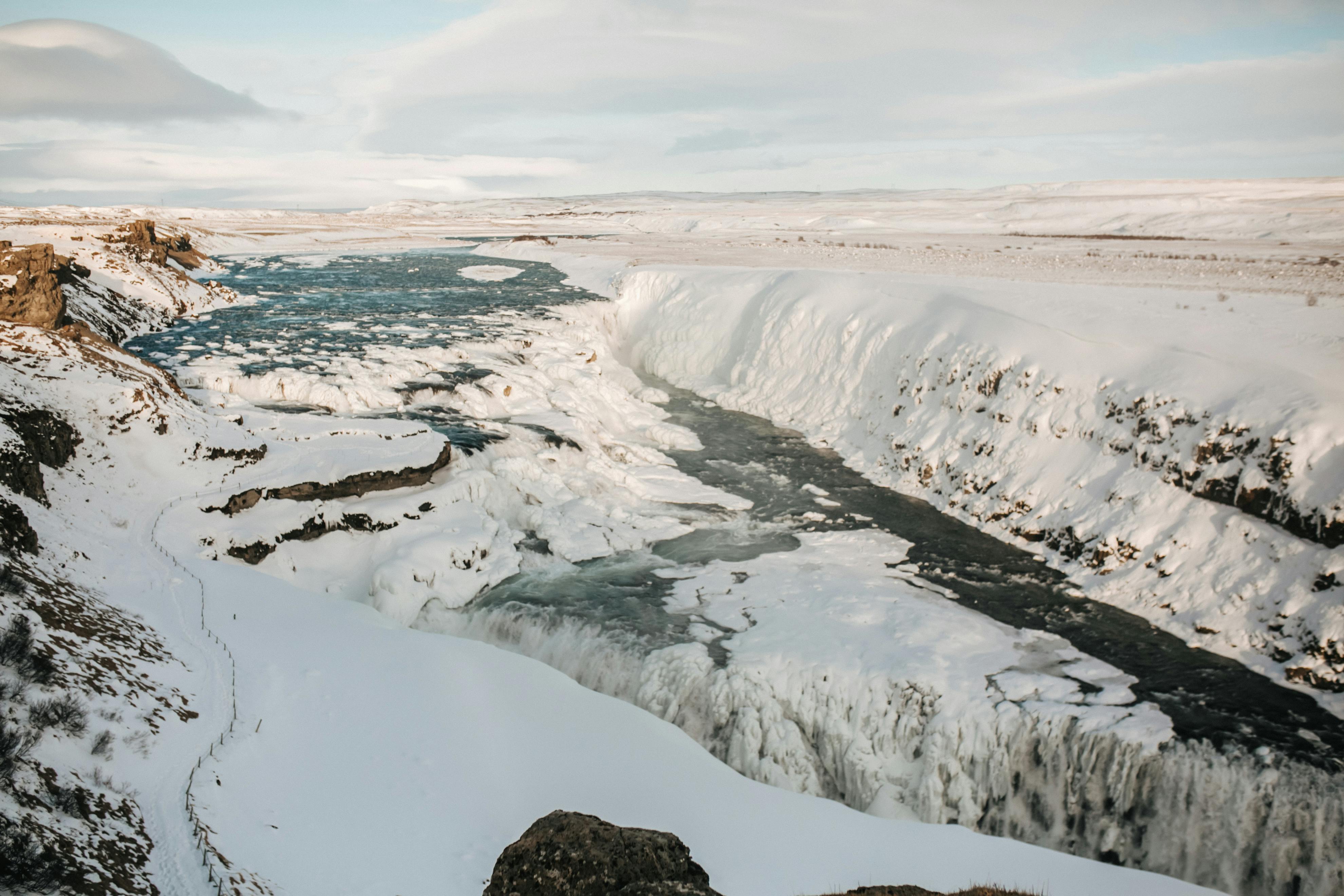 A Frozen River Between Snow Covered Mountains · Free Stock Photo