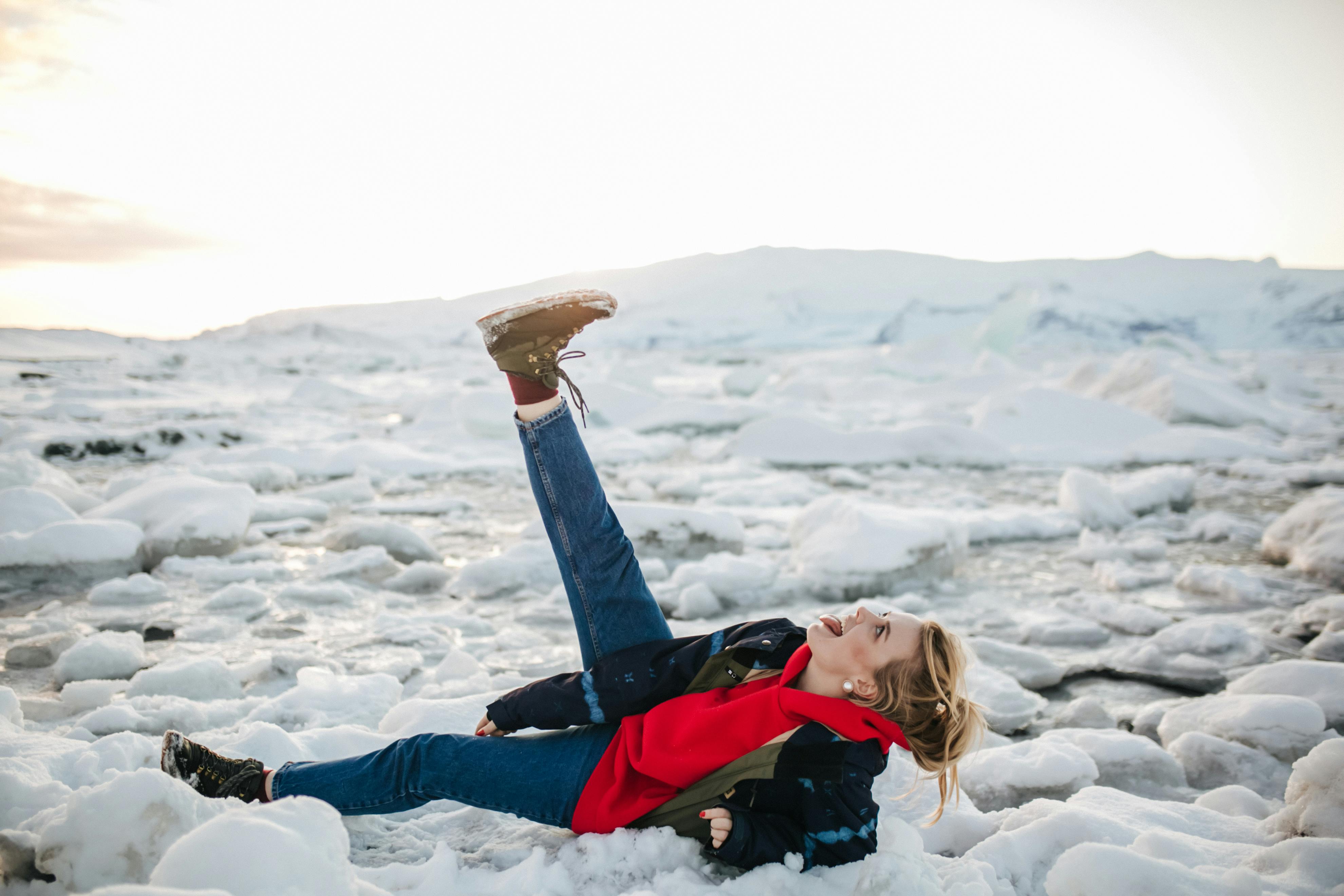 Woman Lying in the Snow with her Leg Raised · Free Stock Photo