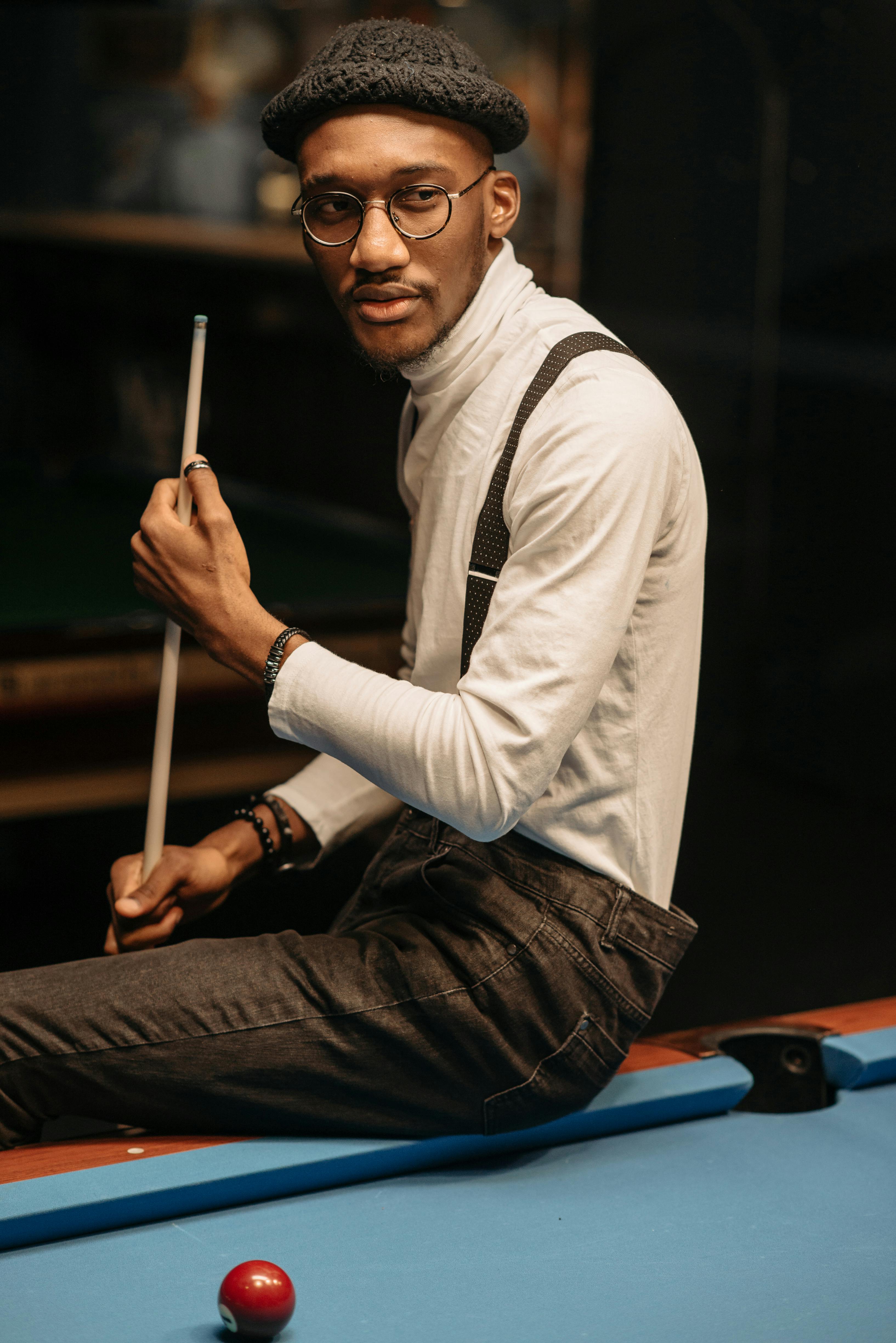 A Man Sitting on a Pool Table · Free Stock Photo