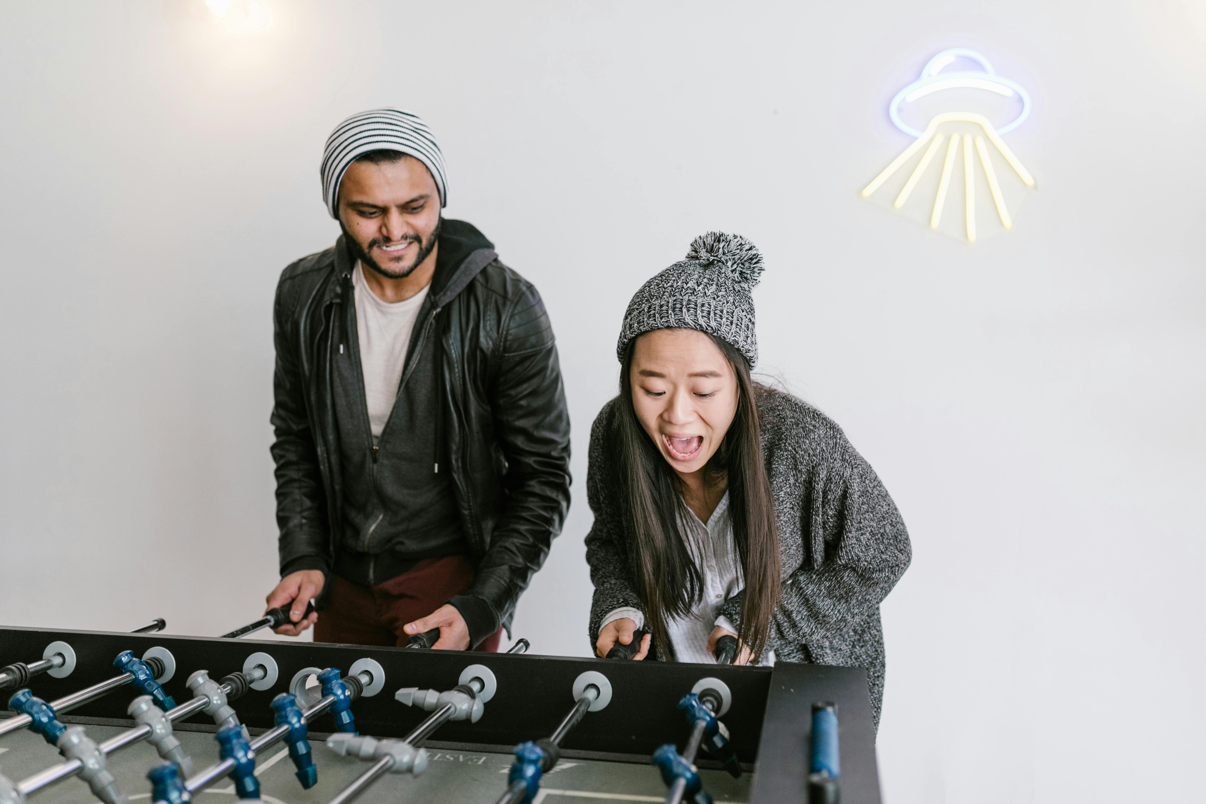 A Man and Woman Playing Foosball · Free Stock Photo