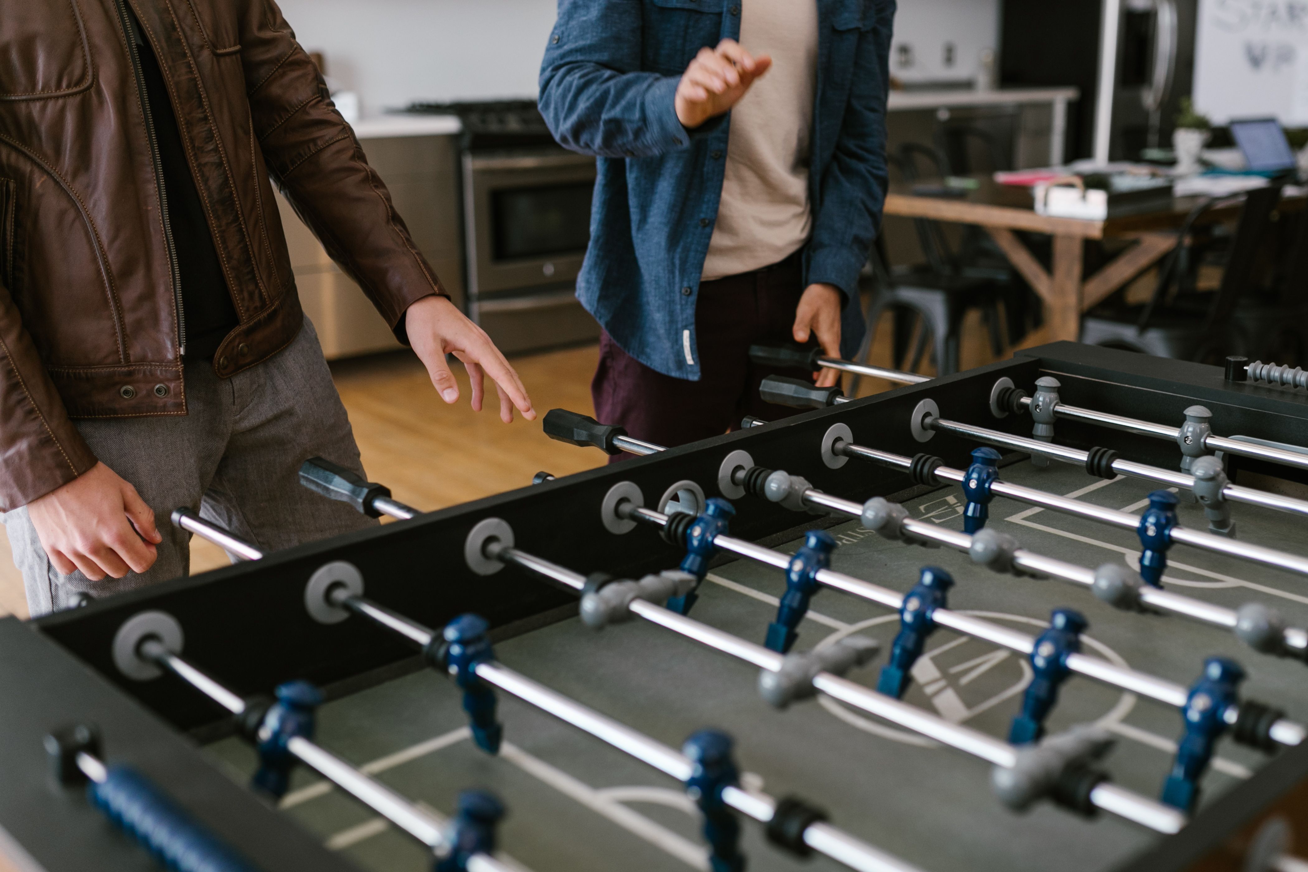 Couple holding Hands playing a Foosball · Free Stock Photo