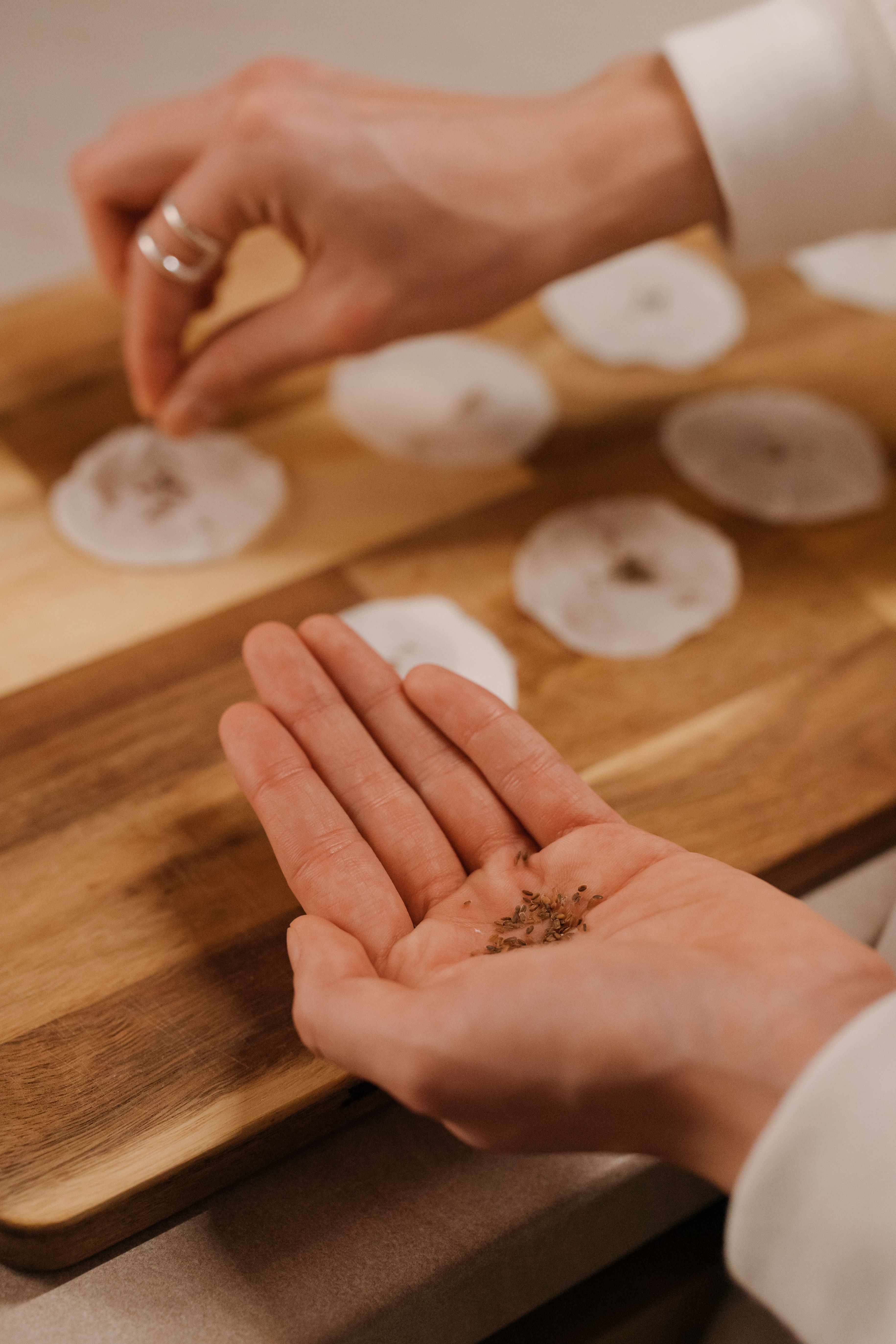 Woman Hands Holding Spices over Wooden Tray · Free Stock Photo
