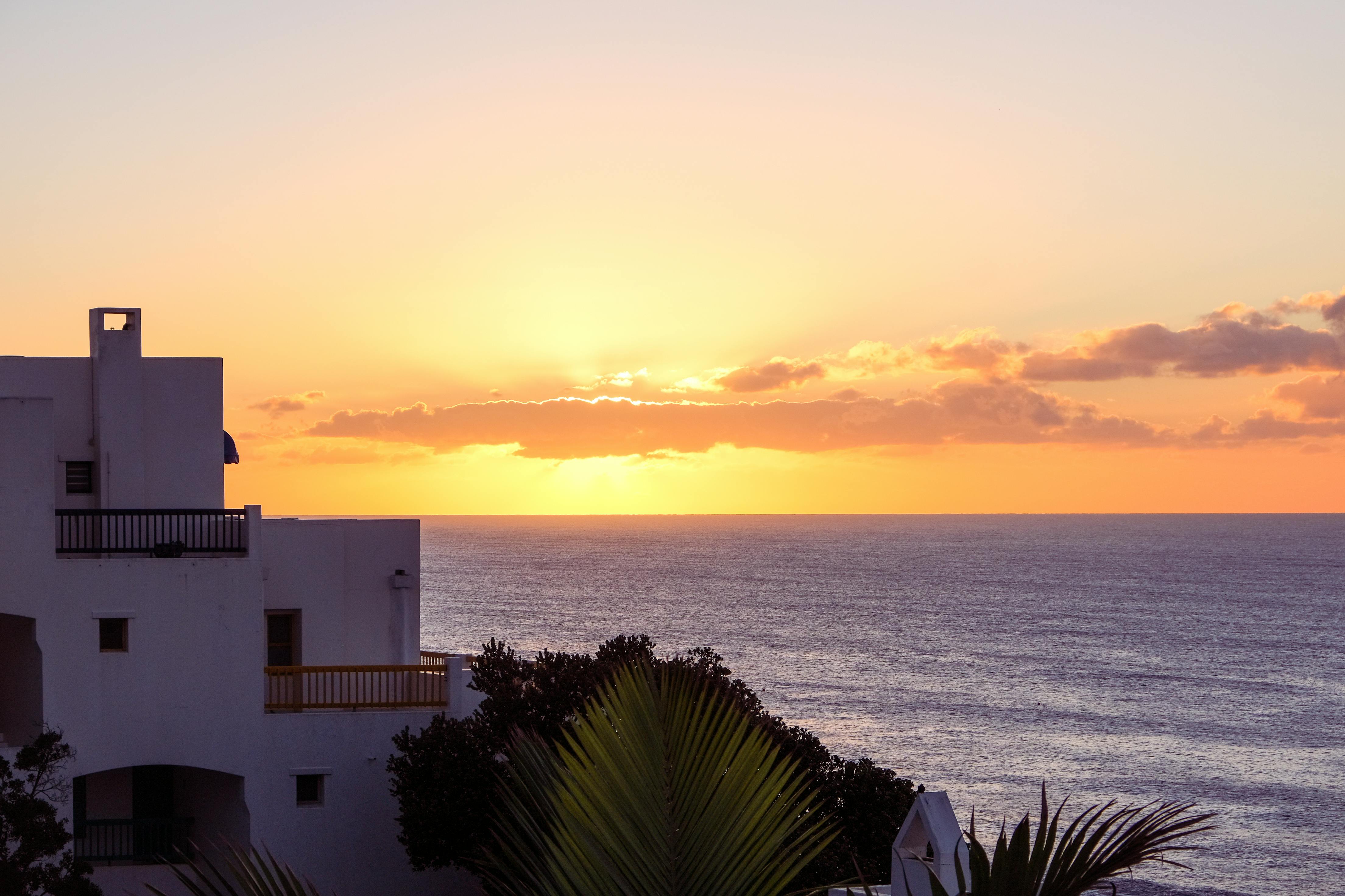 White Concrete Building Near Sea during Sunset · Free Stock Photo