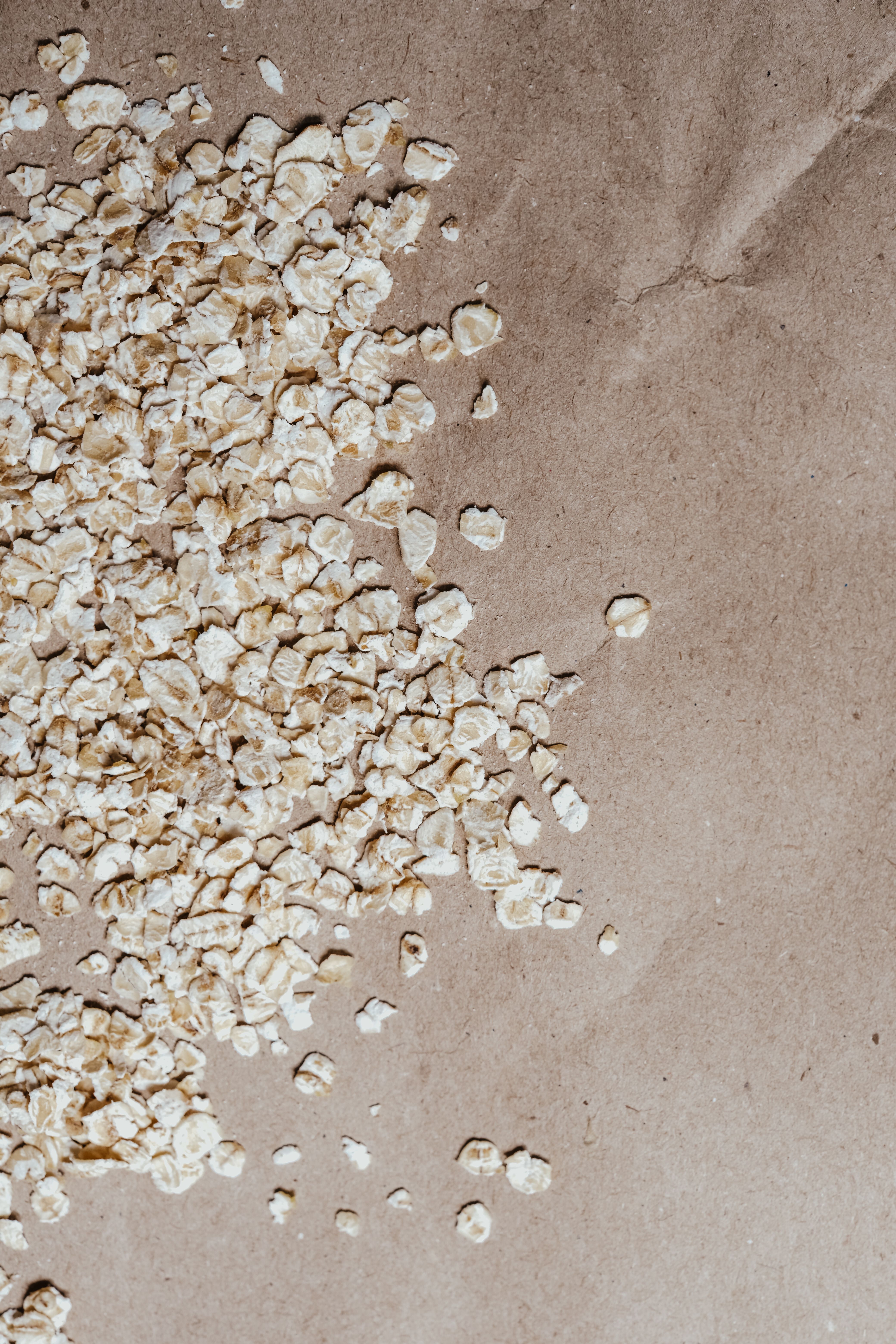 Oatmeals Scattered on Brown Paper · Free Stock Photo