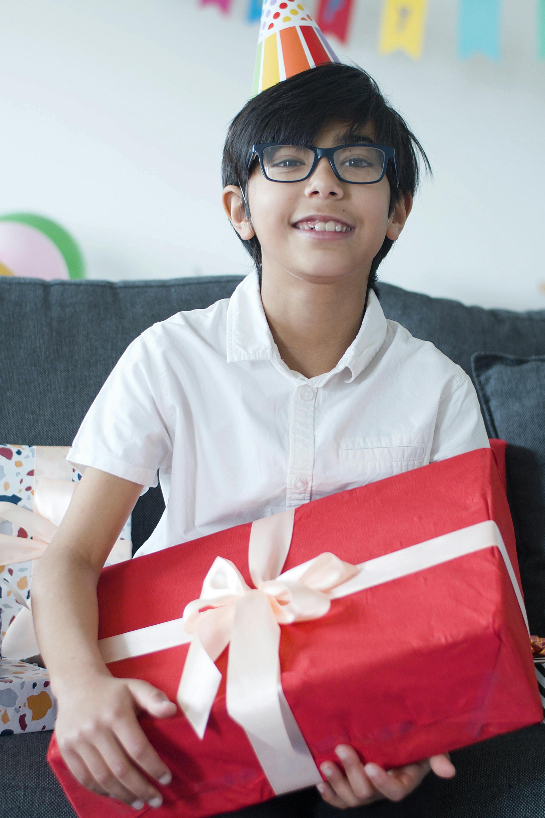 A Kid Opening a Present at a Party · Free Stock Photo