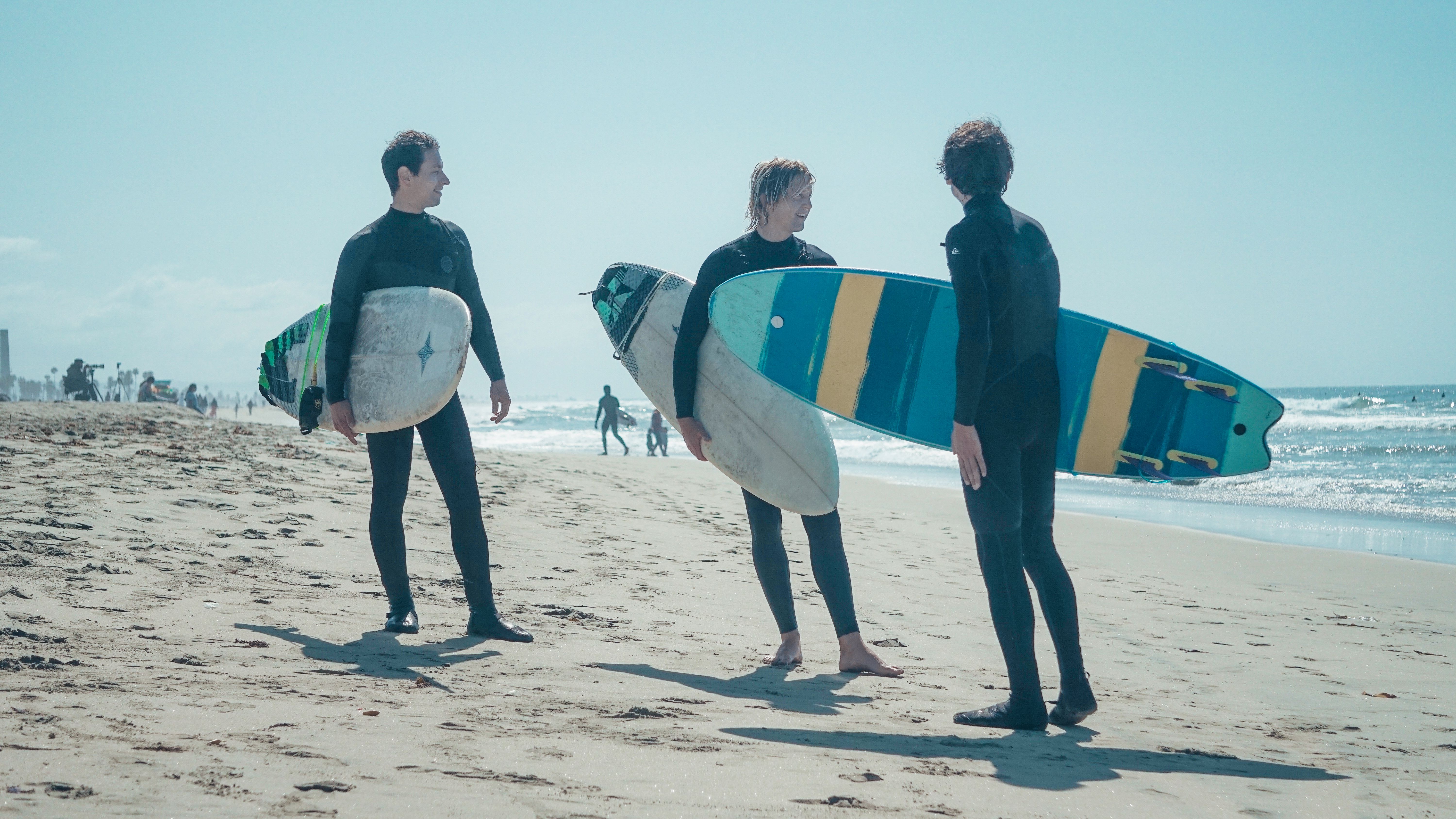 Men Standing on Beach Holding Surfboards · Free Stock Photo