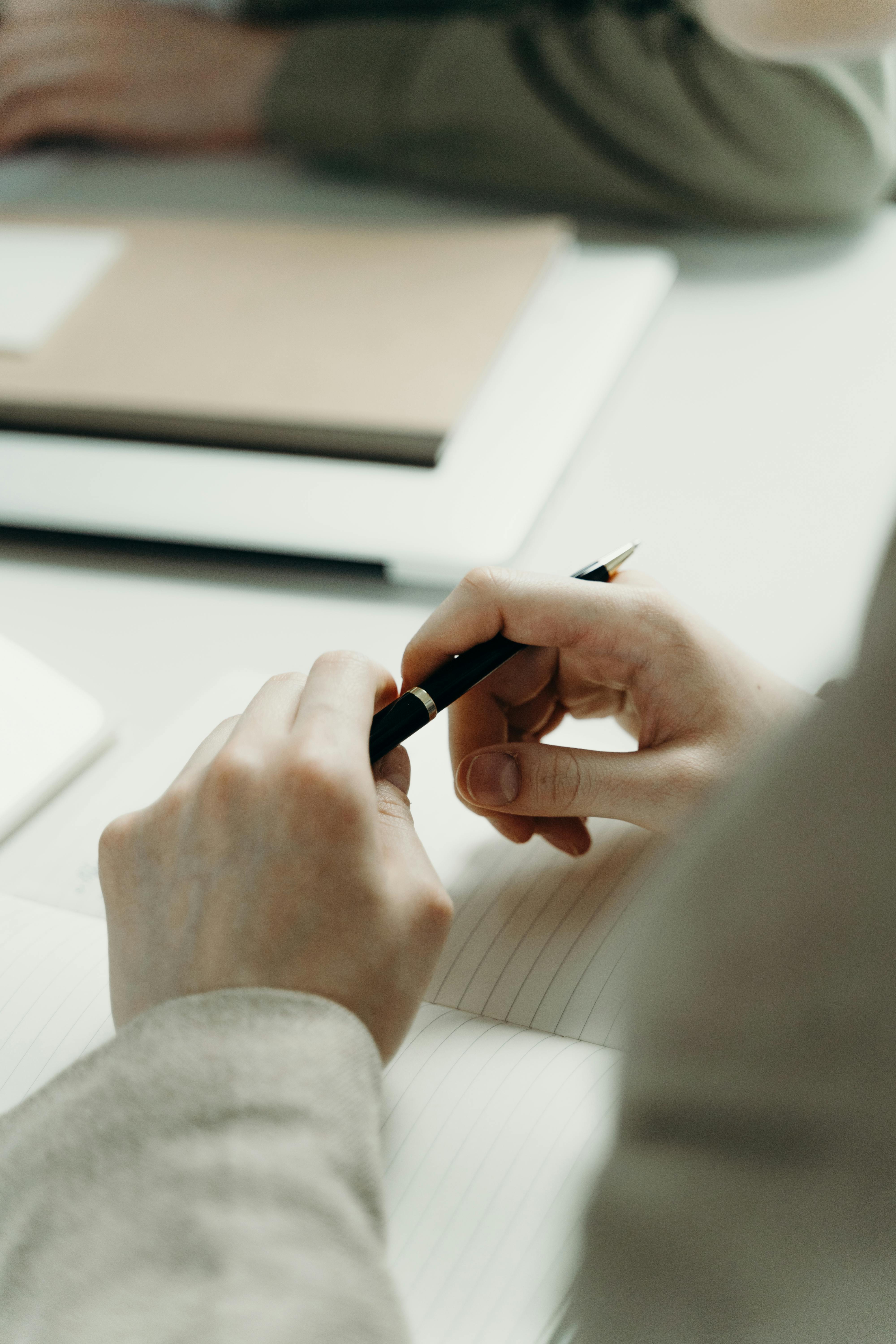 Person Holding a Pen · Free Stock Photo