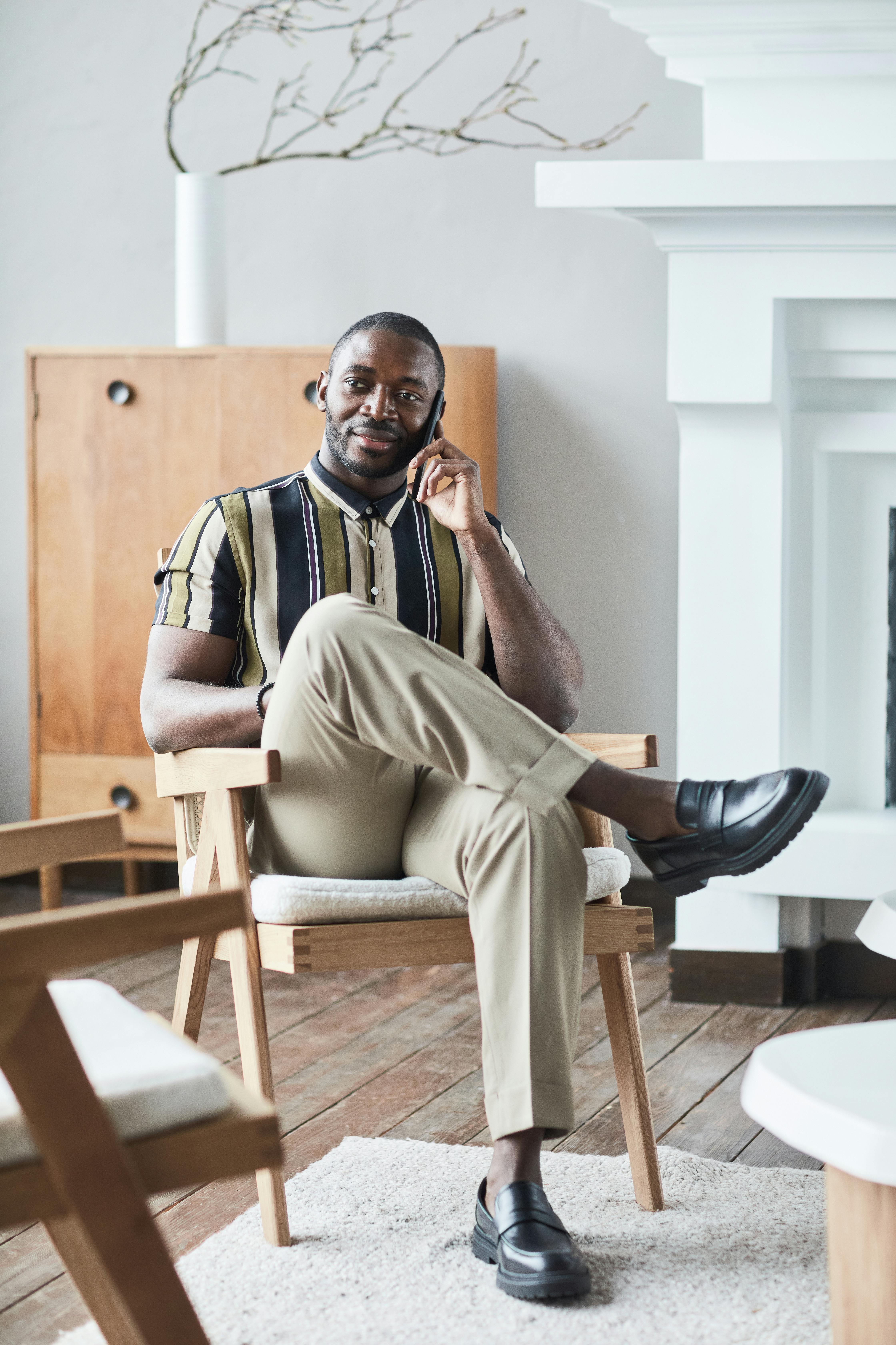 A Man Having a Phone Call while Sitting on a Chair · Free Stock Photo