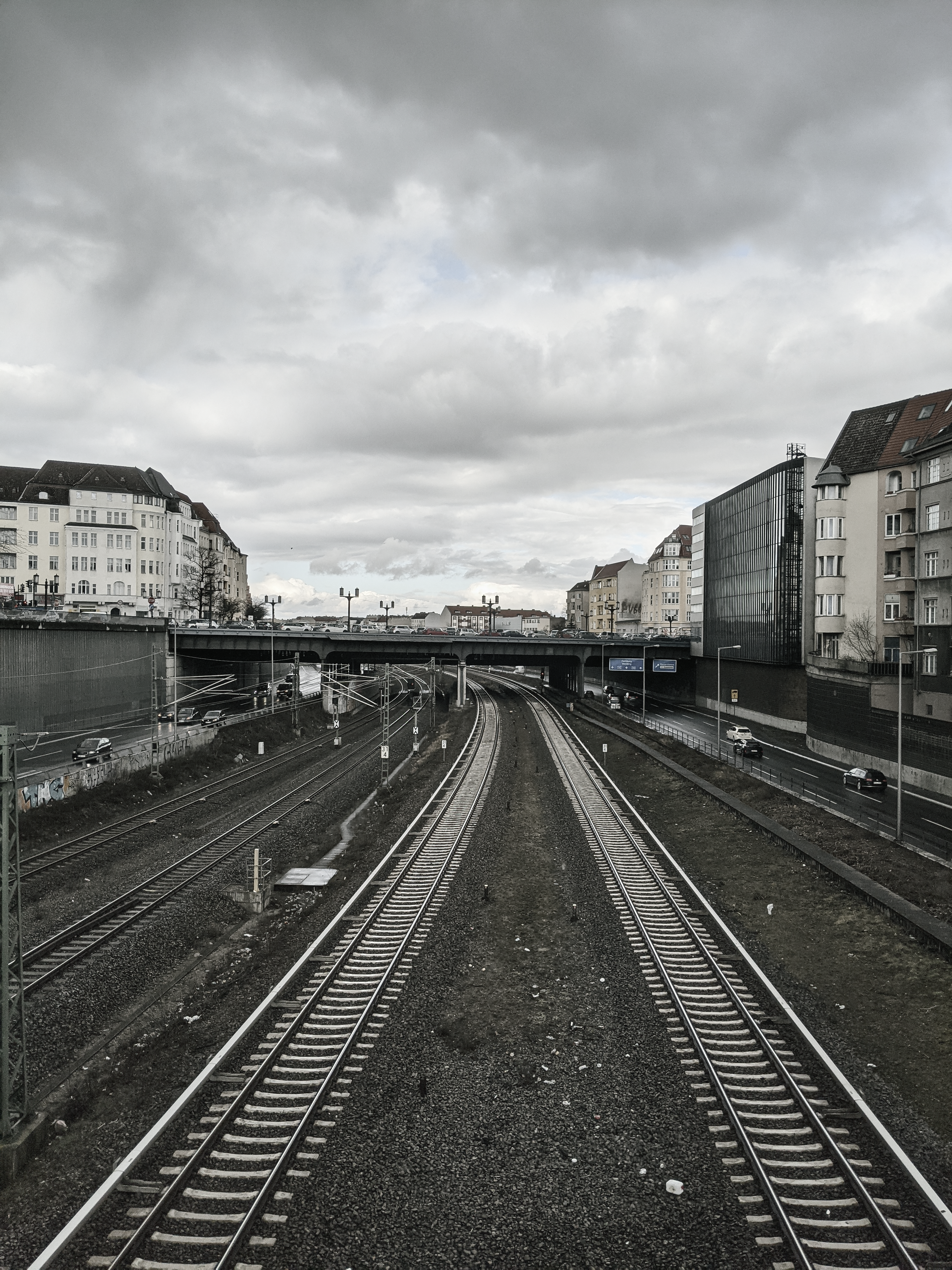 A Grayscale of Train Tracks under a Cloudy Sky · Free Stock Photo