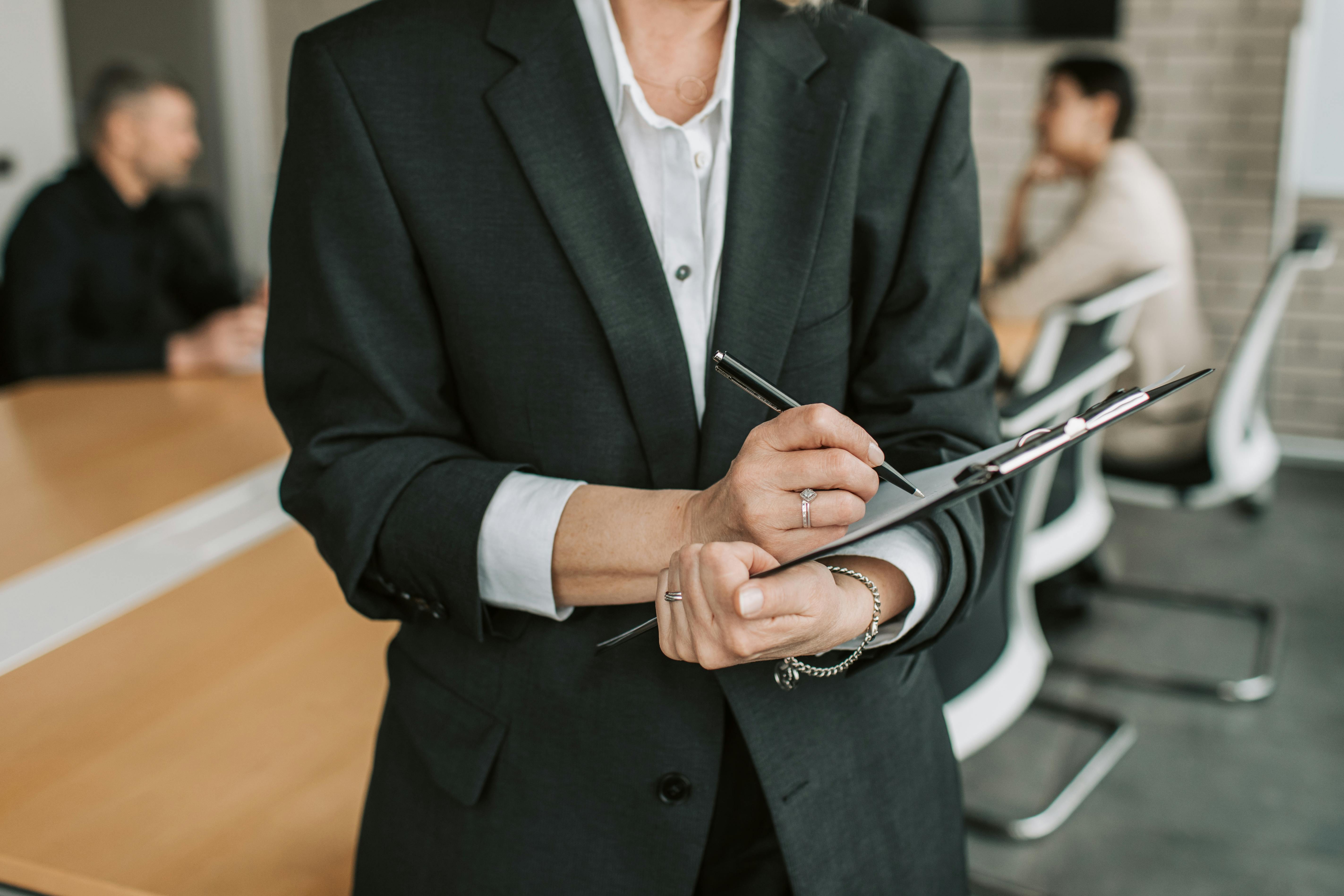 Person in Black Suit Writing on a Paper · Free Stock Photo