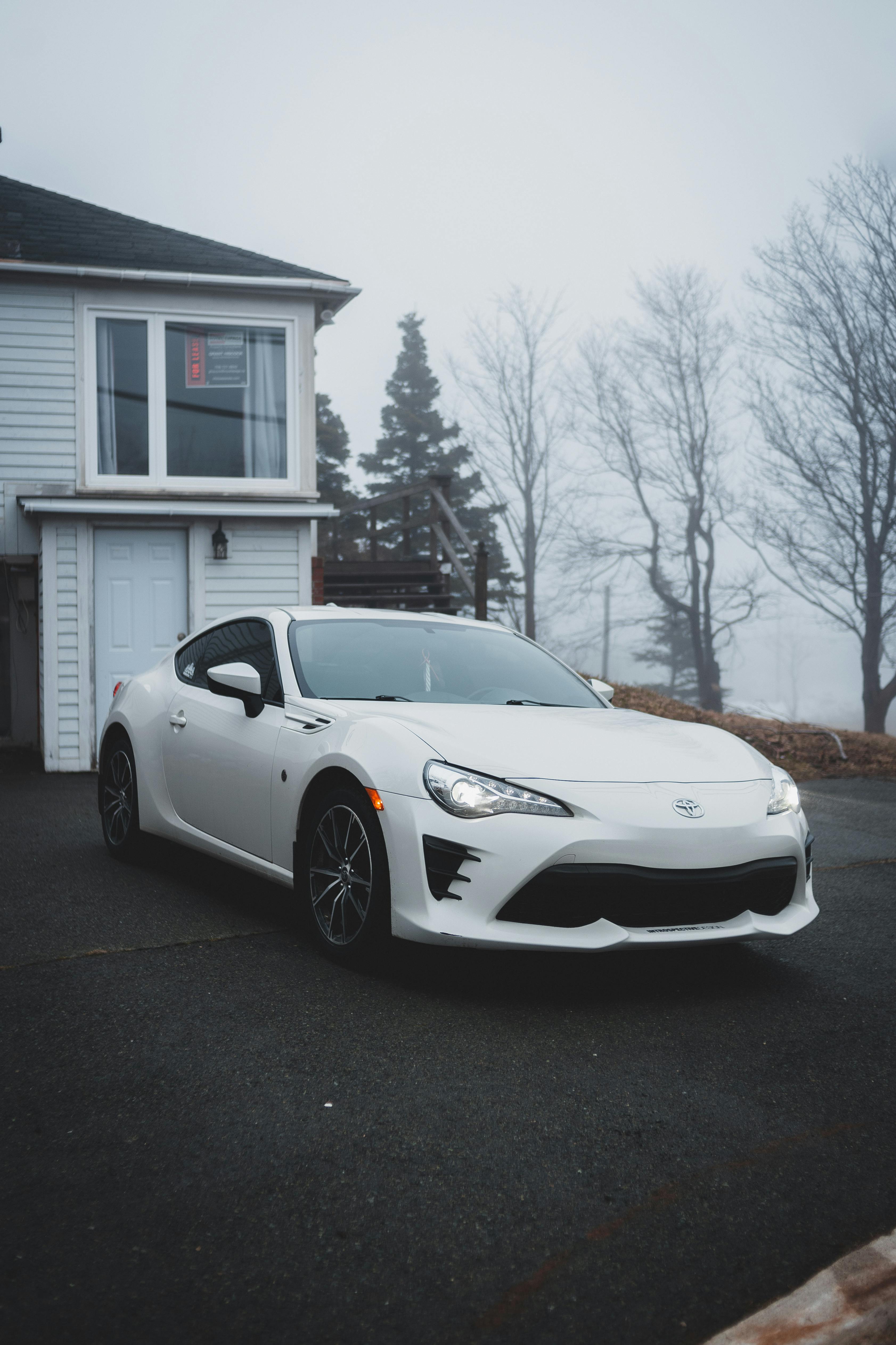 Modern white car parked near shop at night · Free Stock Photo