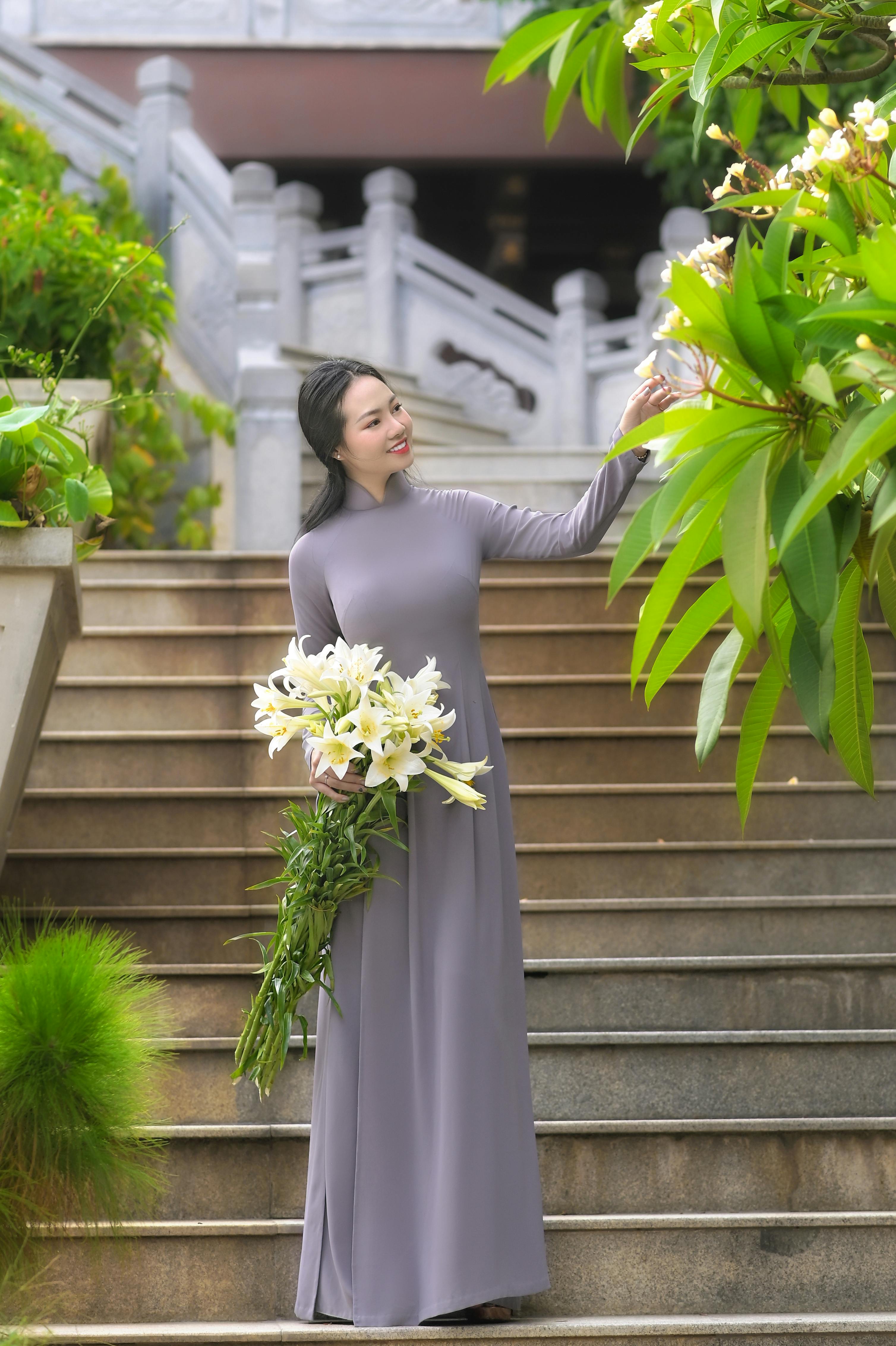 Woman in Traditional Dress Standing Beside a Tree Trunk · Free Stock Photo