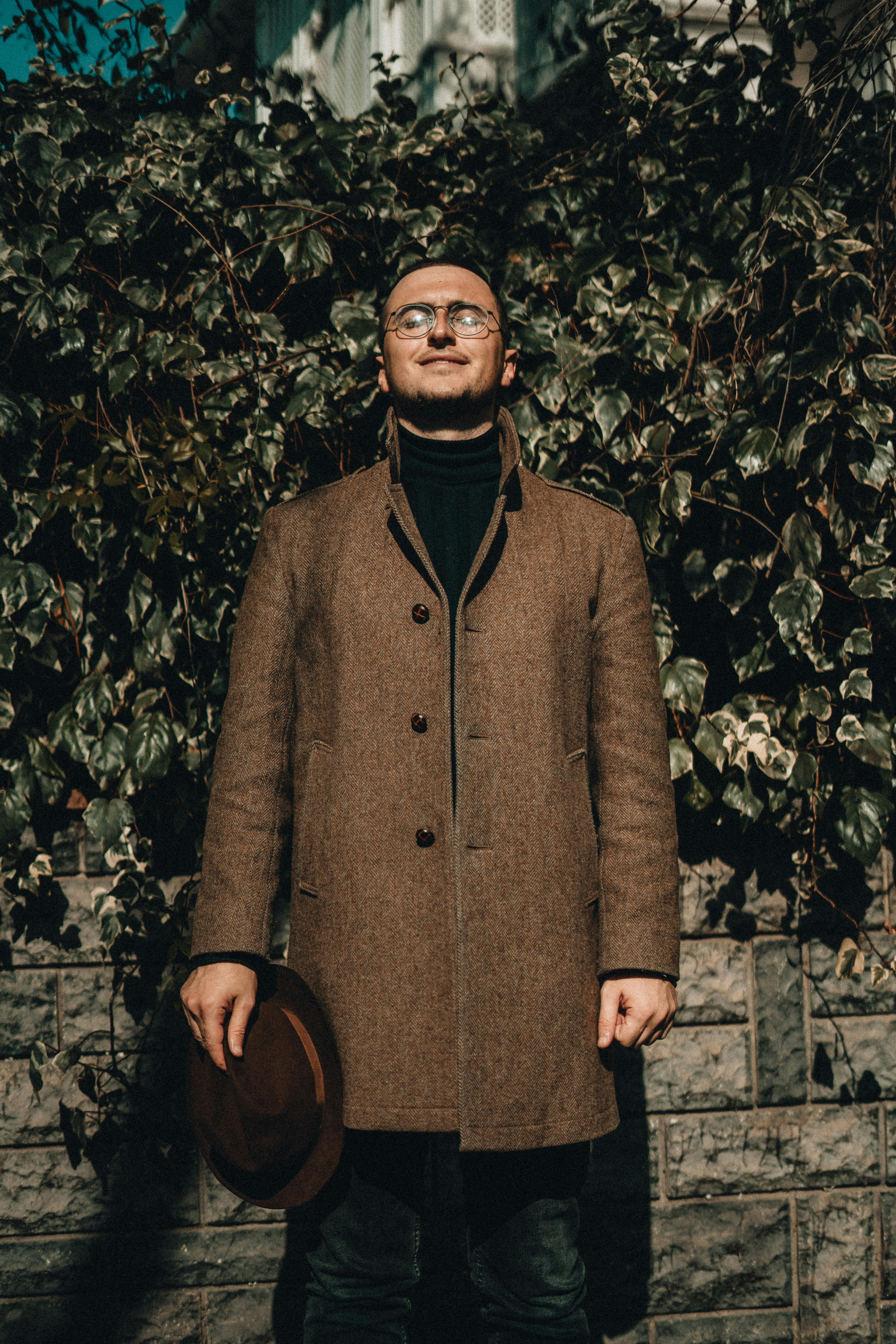 Man Wearing a Coat Standing Under the Sun · Free Stock Photo