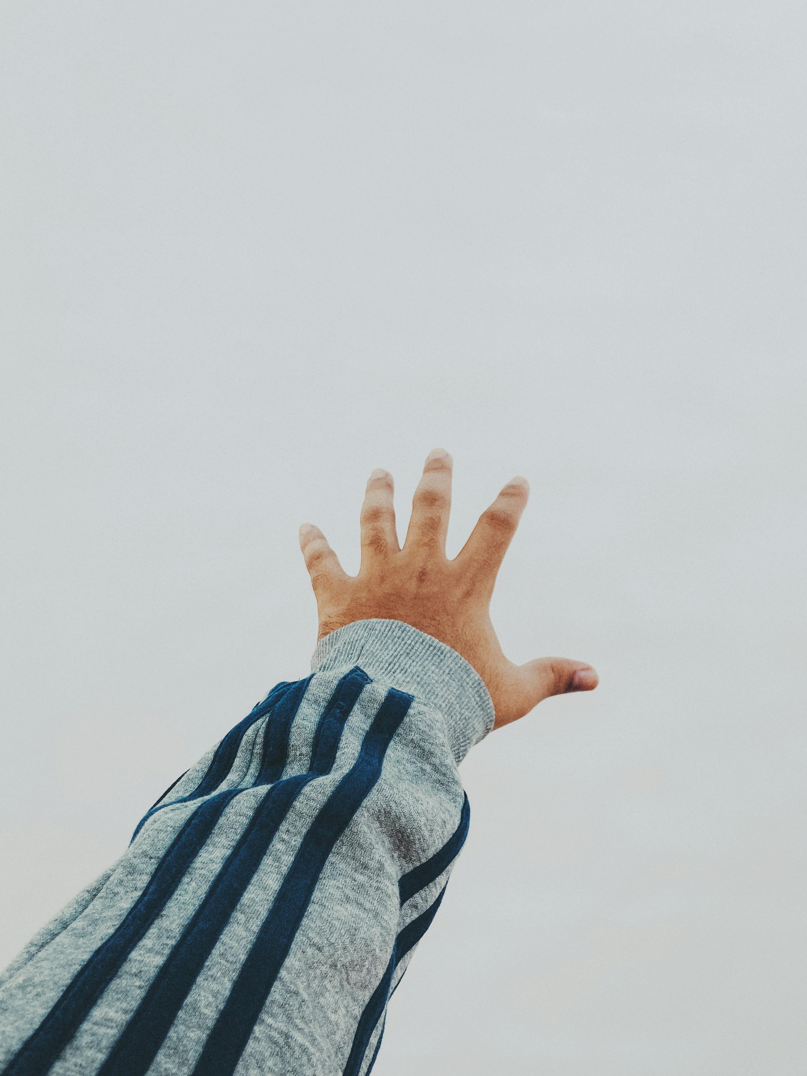 Raised female hand against wall · Free Stock Photo