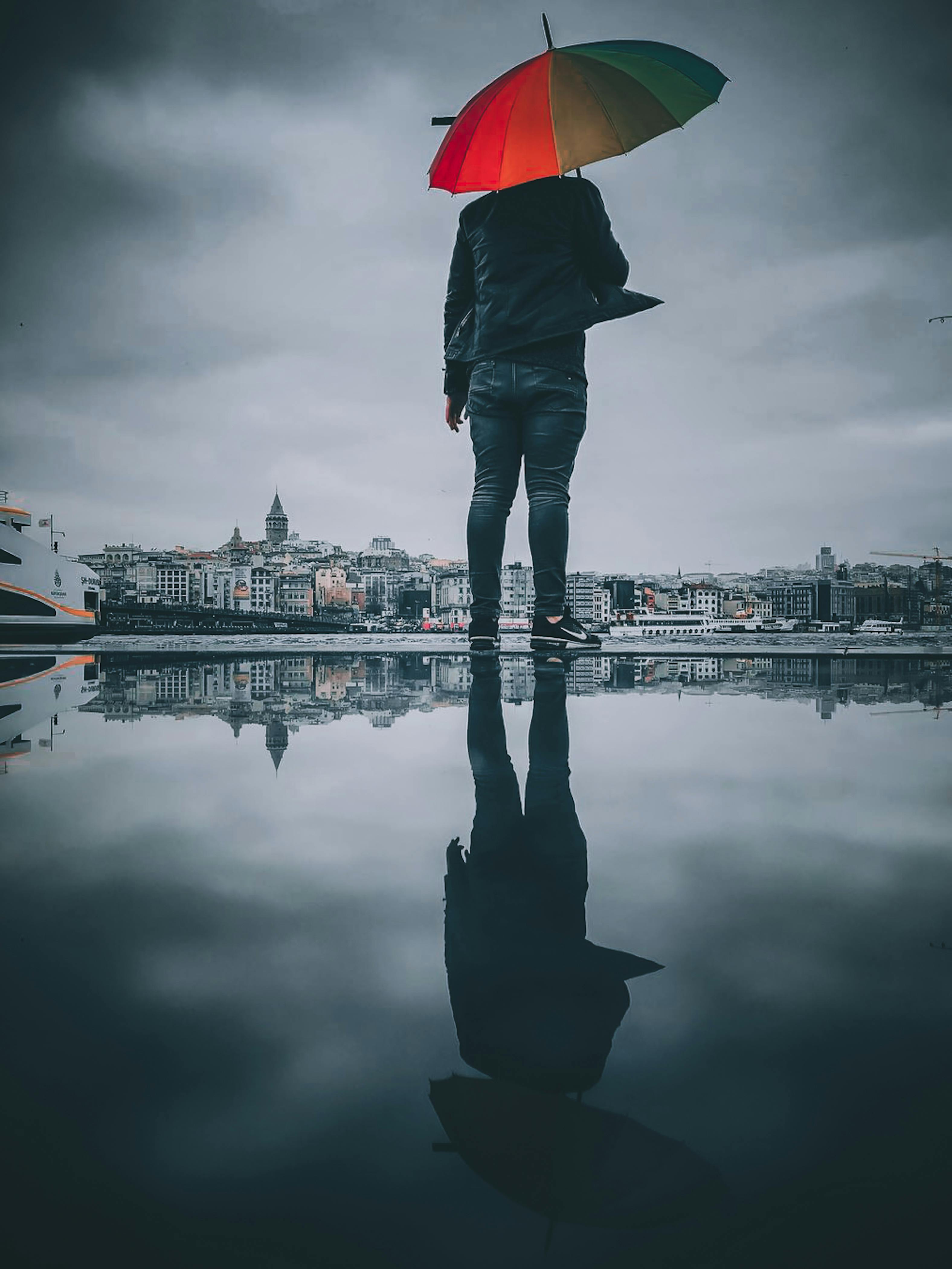 Silhouette of Person Standing on Body of Water · Free Stock Photo
