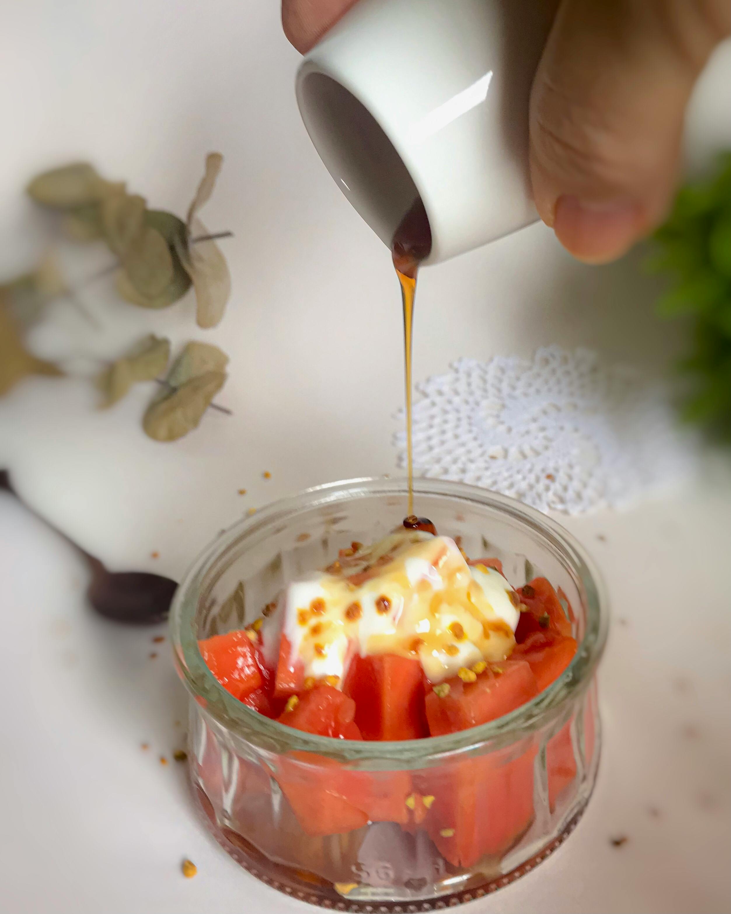 A Person Pouring Syrup into a Bowl of Dessert · Free Stock Photo