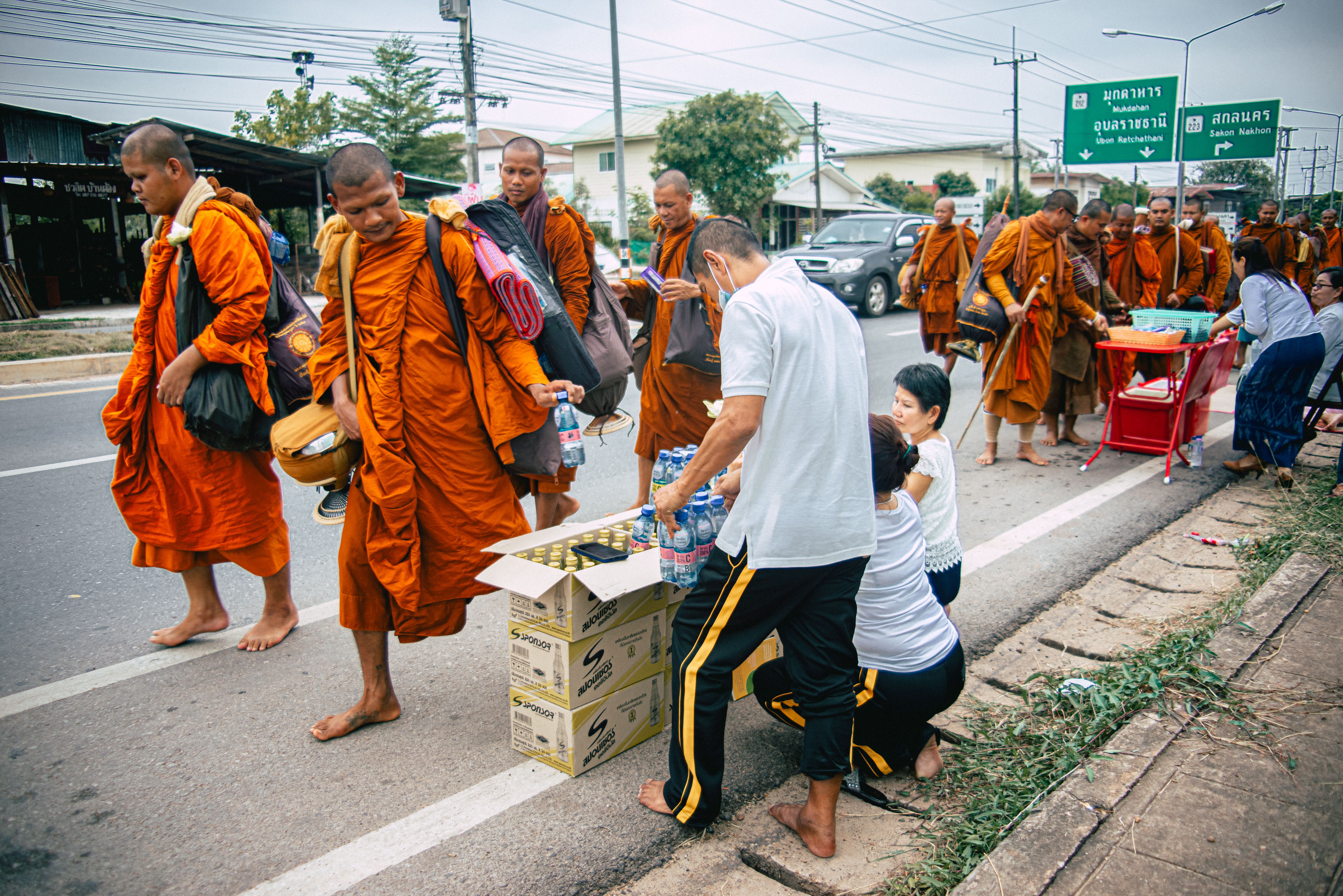 People on the Side of the Road Giving Water to Walking Monks · Free ...