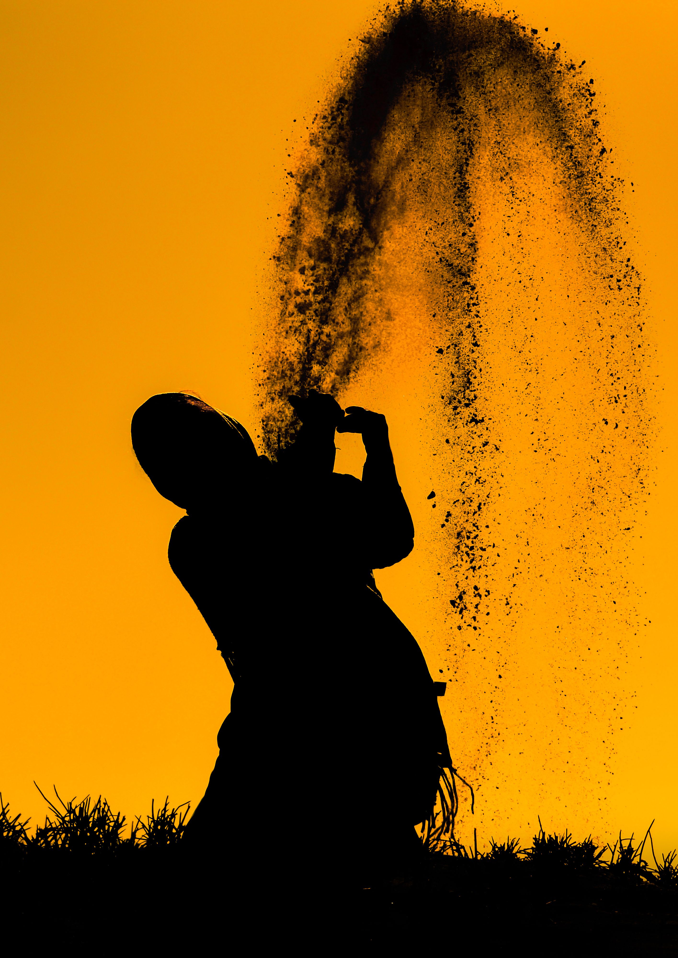 Silhouette of Person Throwing Sand · Free Stock Photo