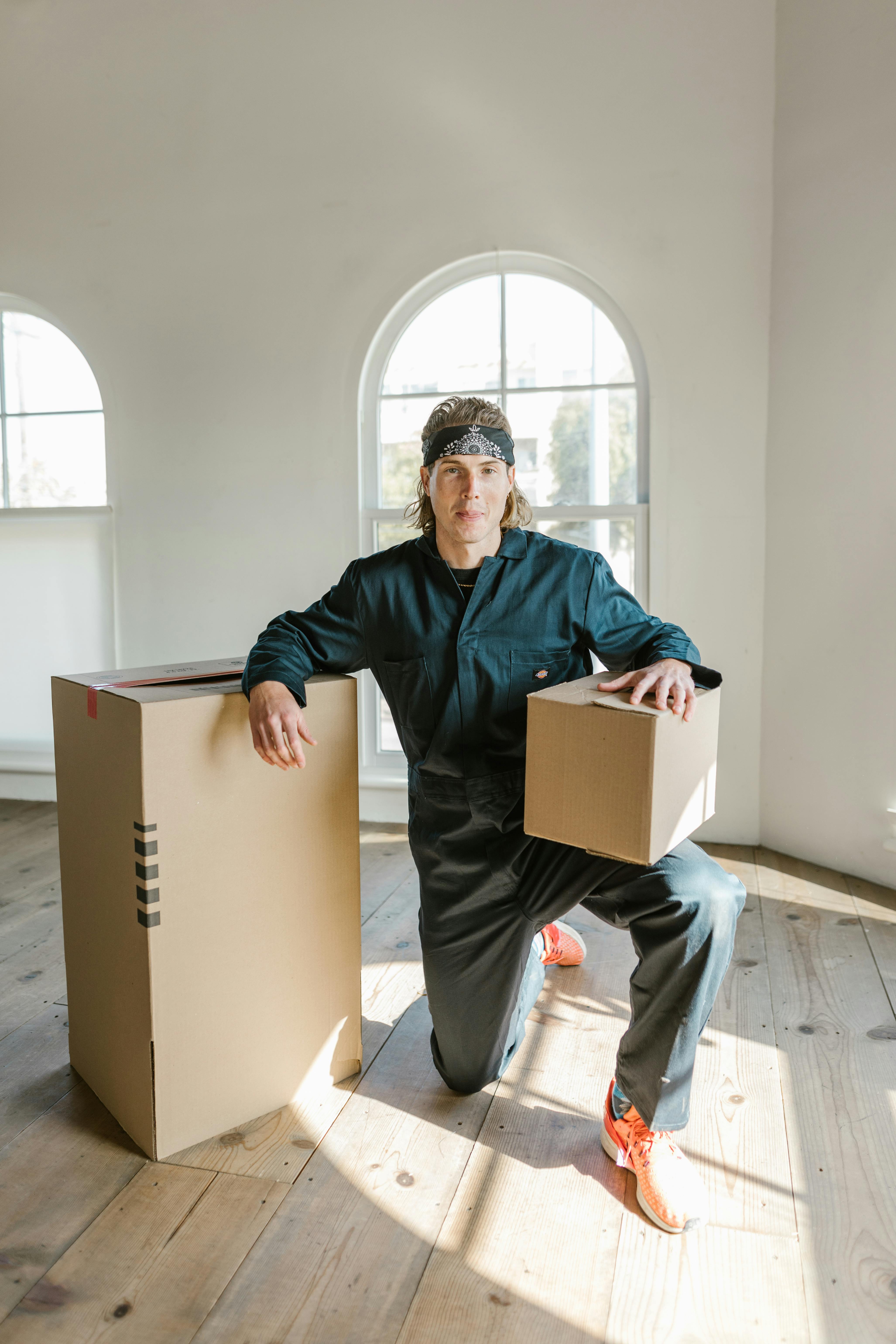 Two Men Standing Carrying Cardboard Boxes · Free Stock Photo