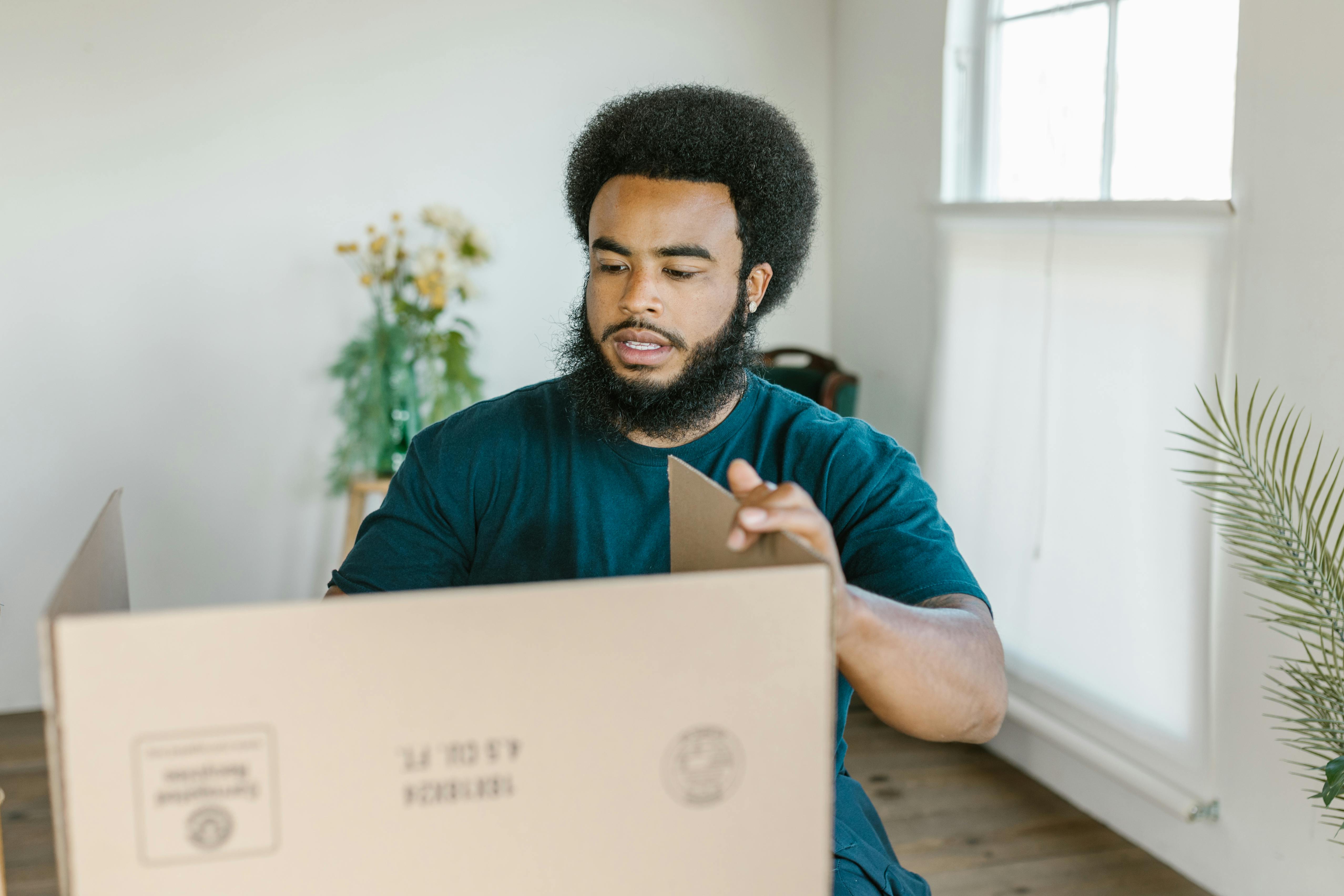 A Man Holding a Cardboard Box · Free Stock Photo