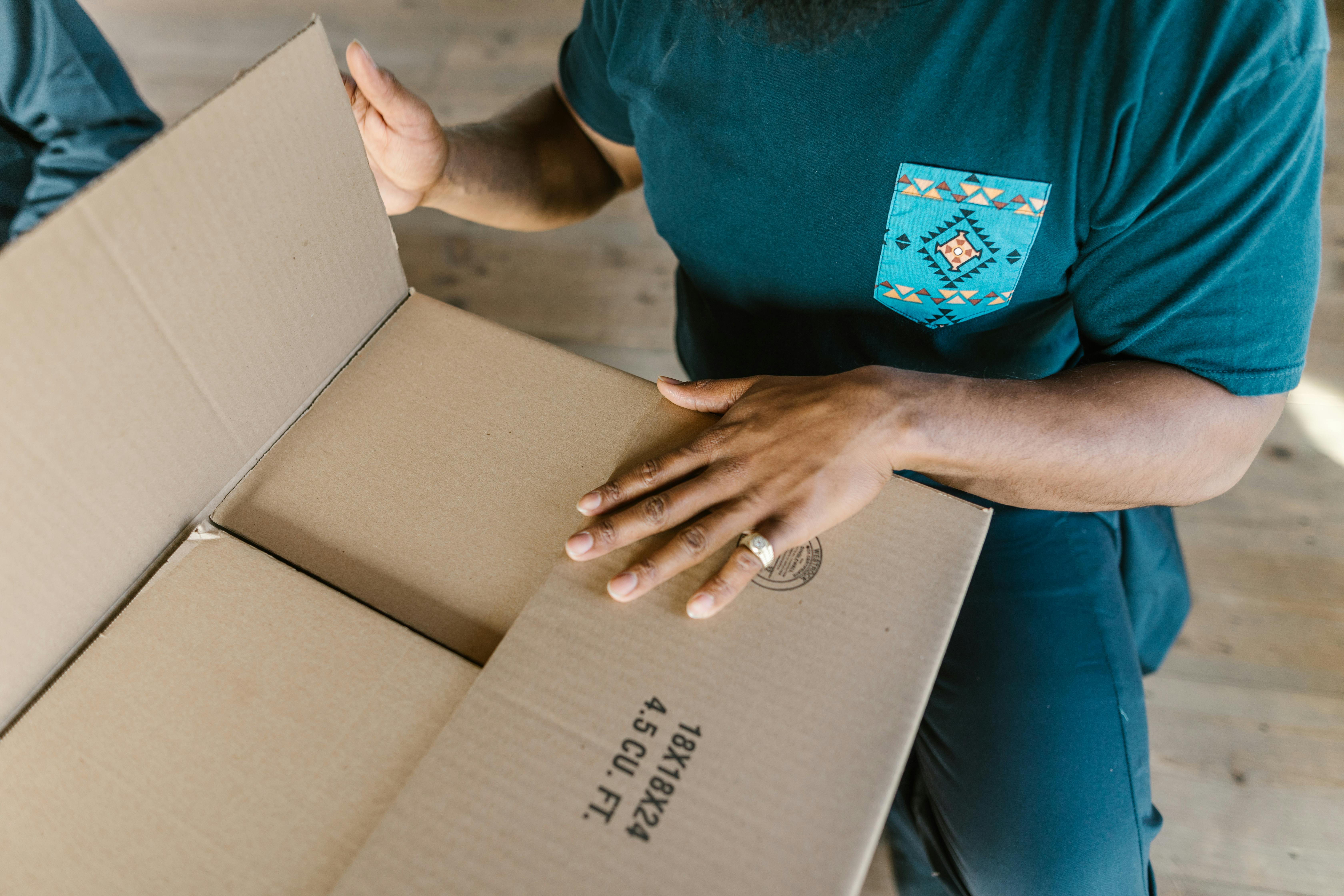 Close-Up Shot of a Person Holding a Cardboard Box · Free Stock Photo